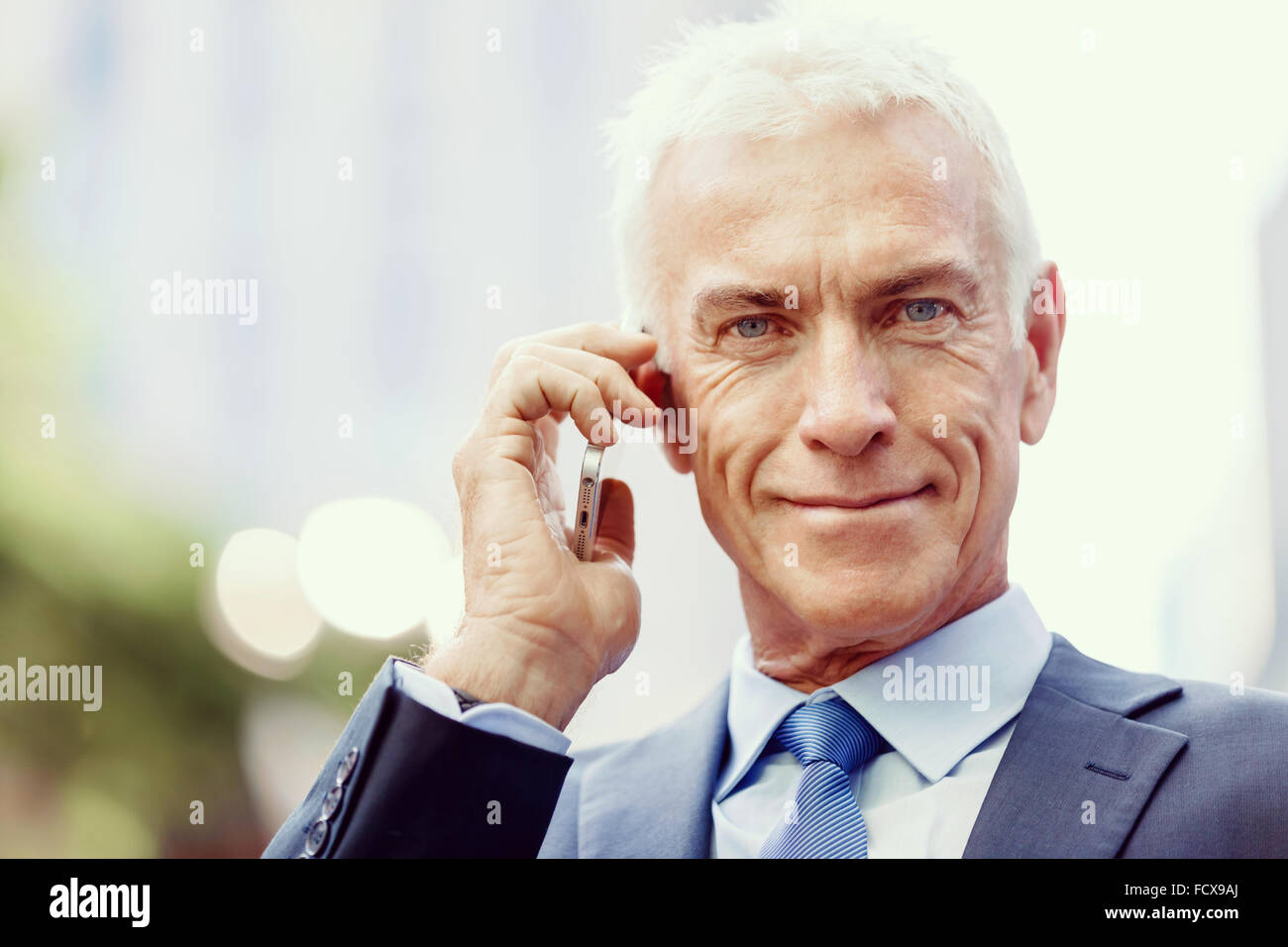 Portrait Of Confident Businessman With His Mobile Phone Outdoors Stock