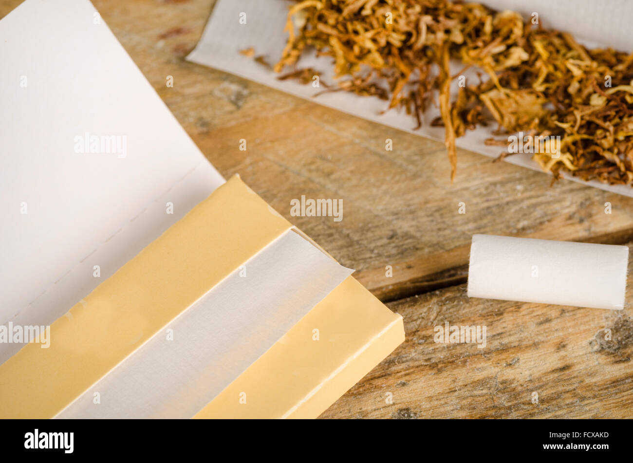 Accesories for rolling and smoking cigarettes on a rustic wooden table ...