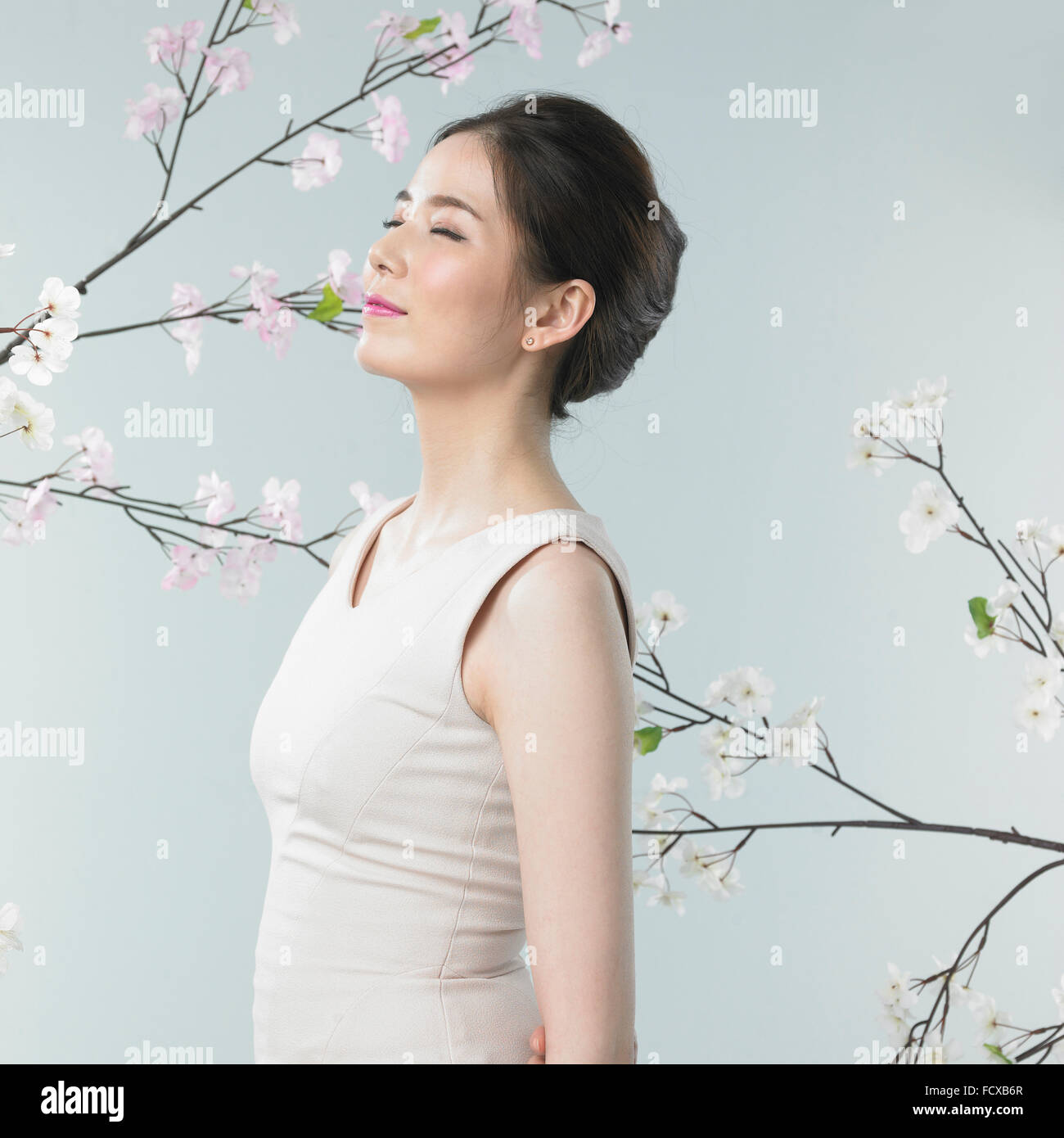 Woman with pink lip make-up closing her eyes with her head raised with ...