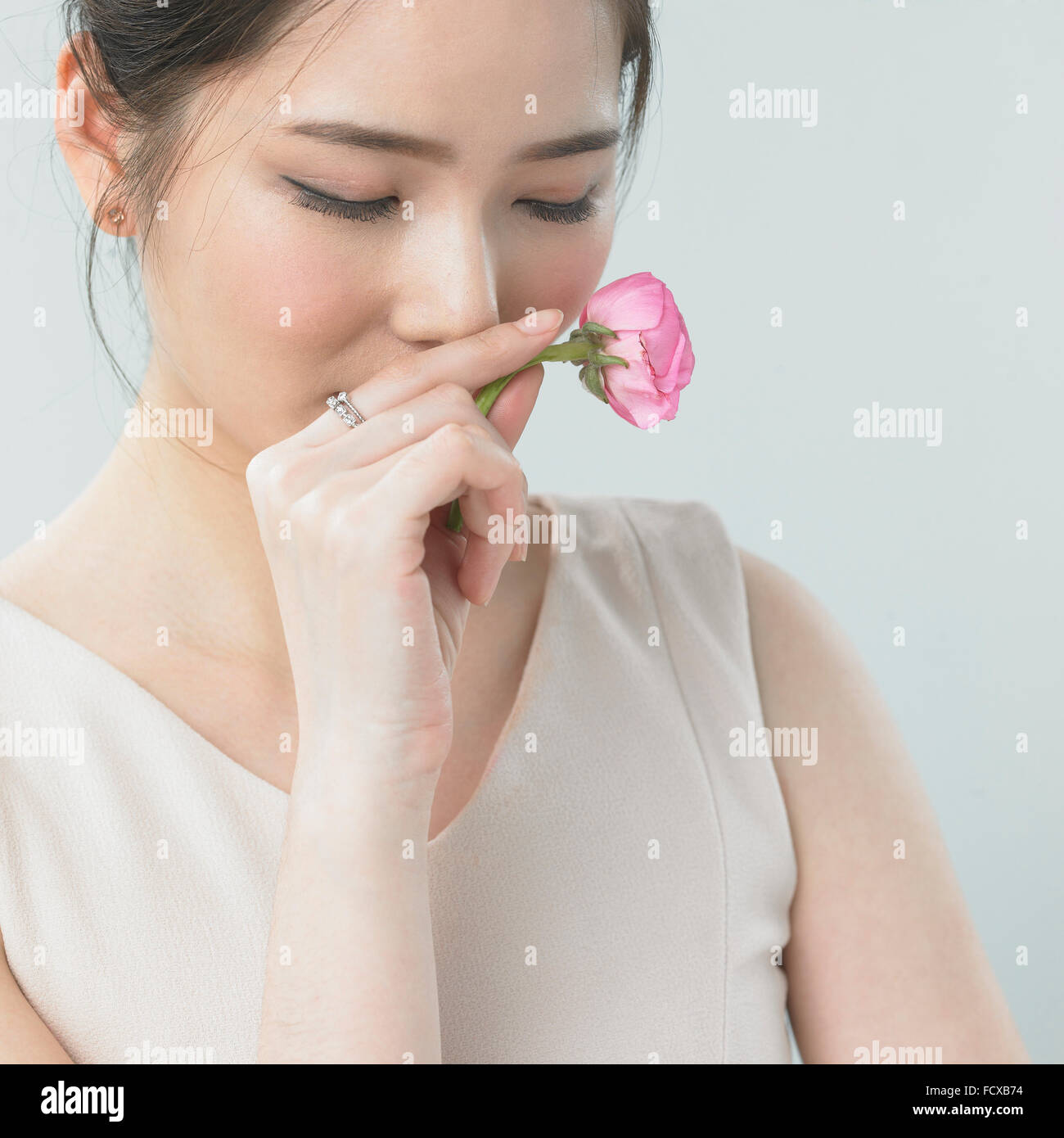 Woman smelling a rose with her eyes closed Stock Photo - Alamy