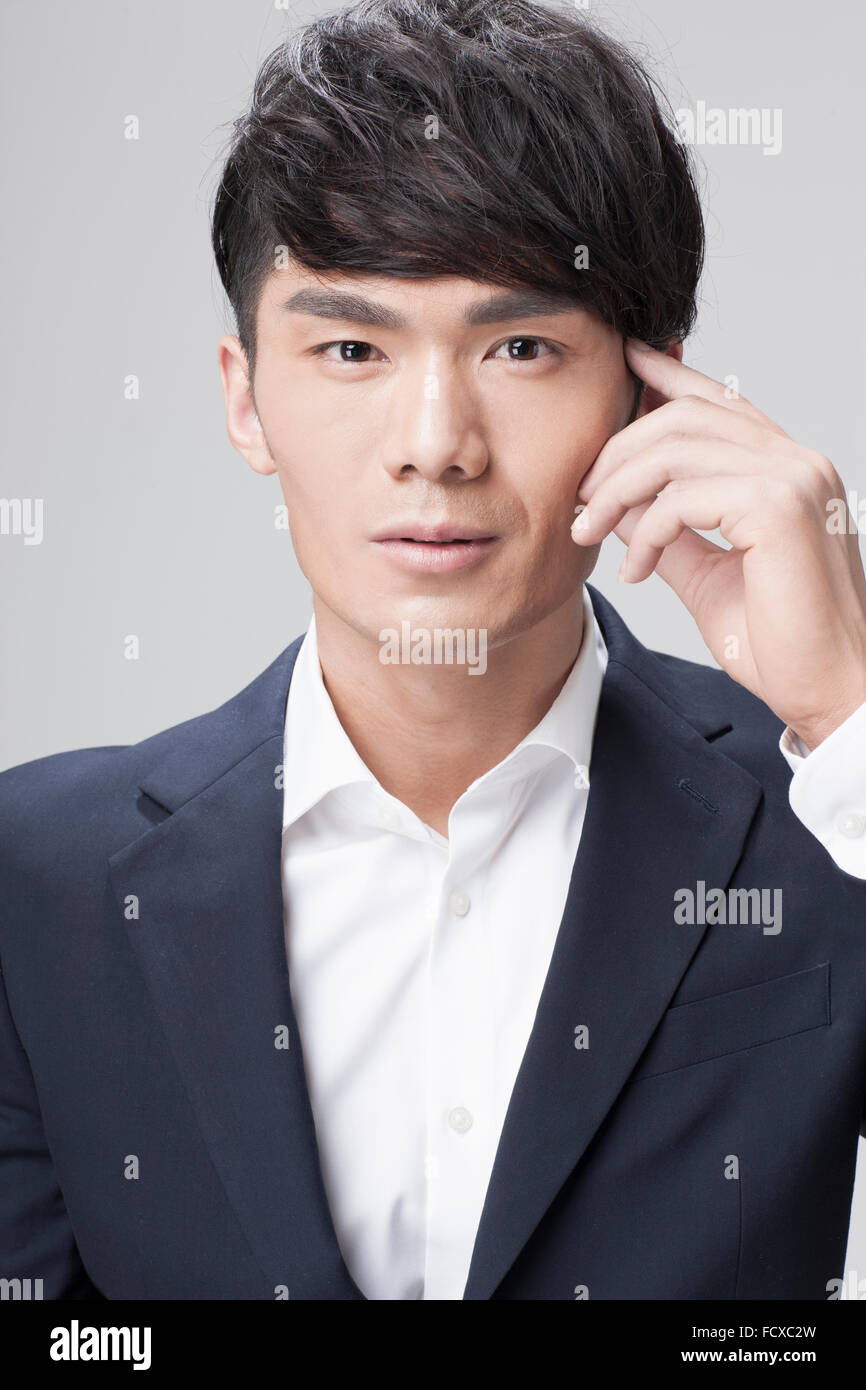 Man in black suit staring forward with the gesture of thinking Stock ...