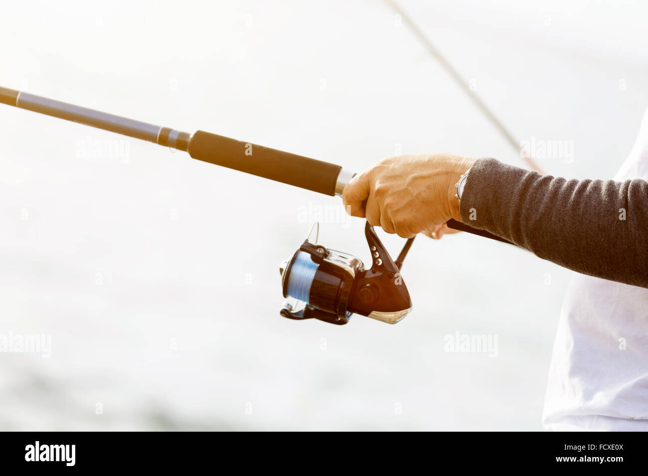 Picture of fisherman's hands holding rod and fishing Stock Photo - Alamy