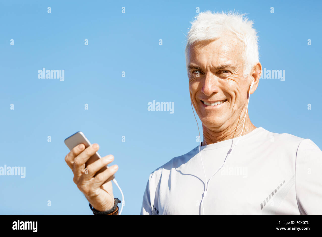 Young male runner with his mobile smart phone standing outdoors Stock ...