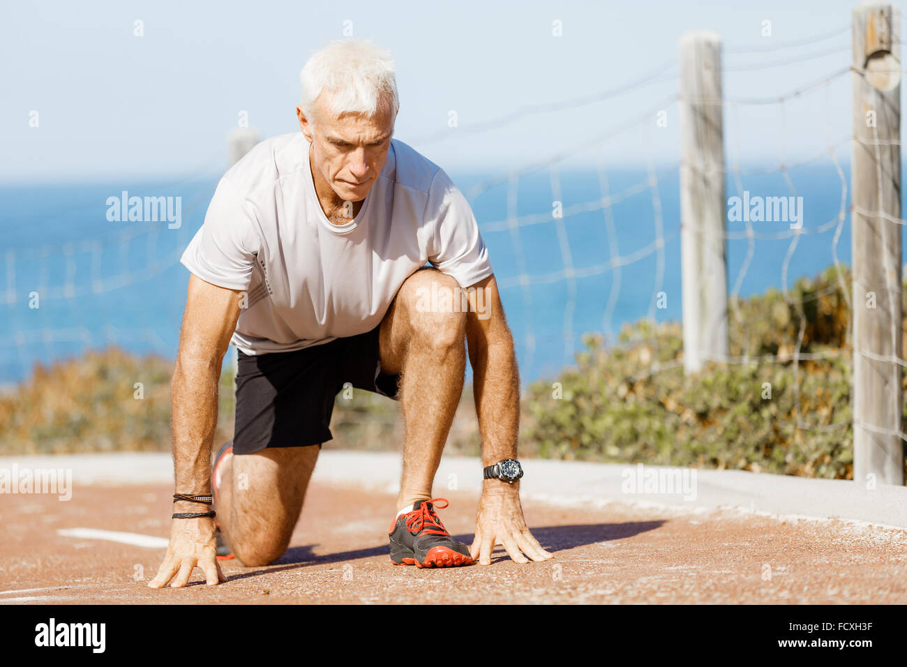 Male runner getting ready to start his race Stock Photo - Alamy