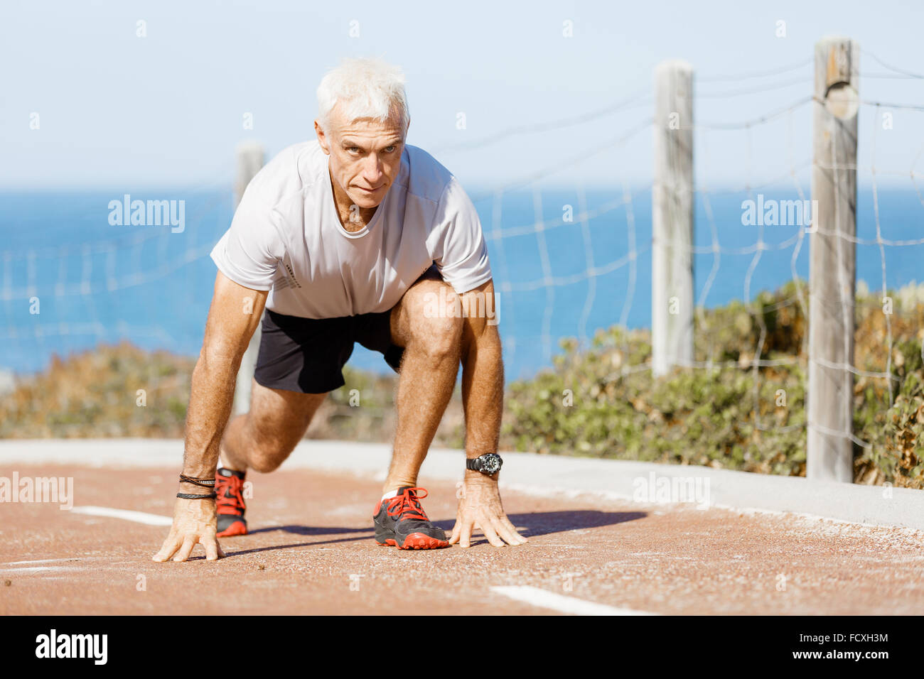 Male runner getting ready to start his race Stock Photo - Alamy
