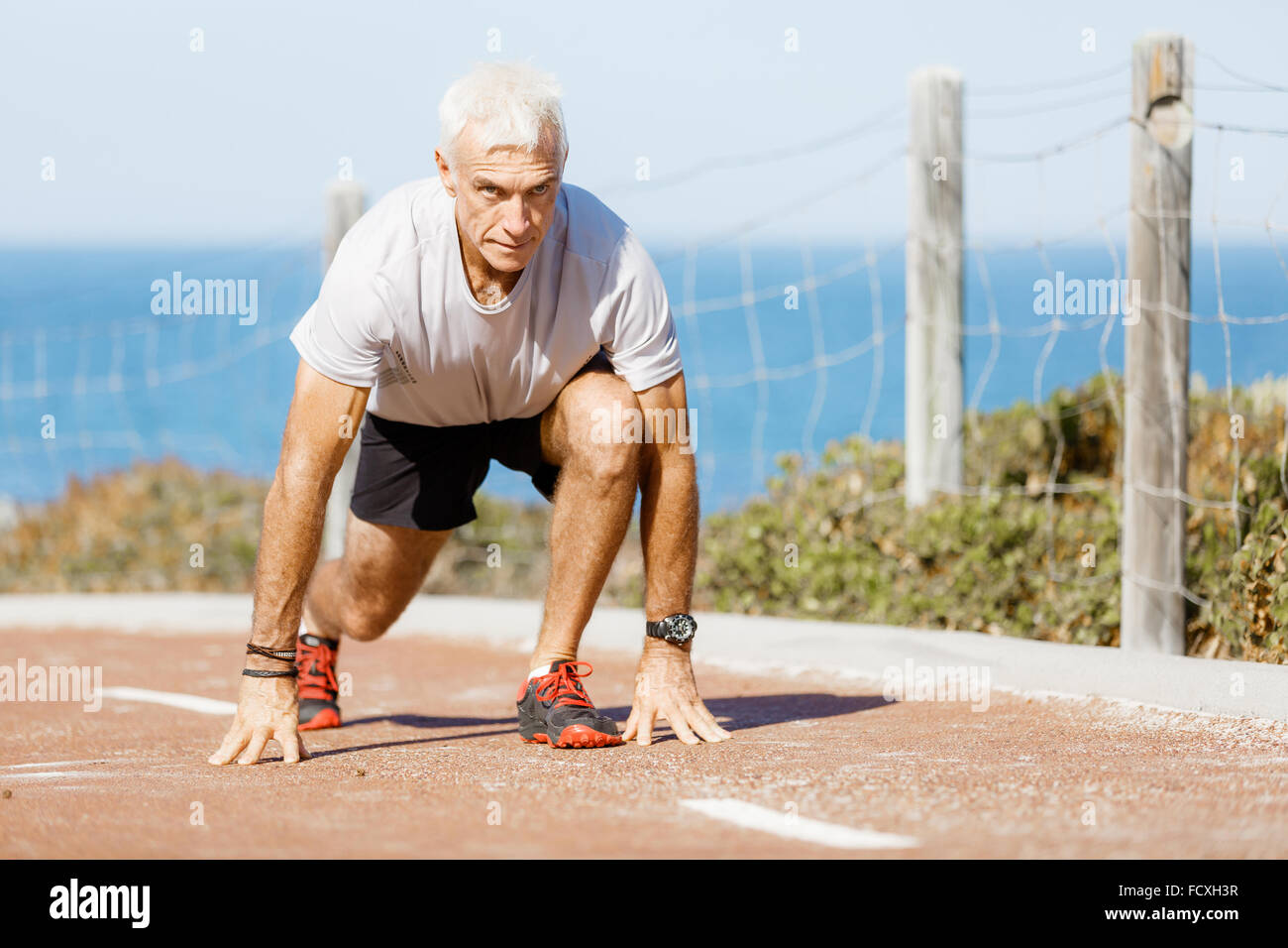 Male runner getting ready to start his race Stock Photo - Alamy