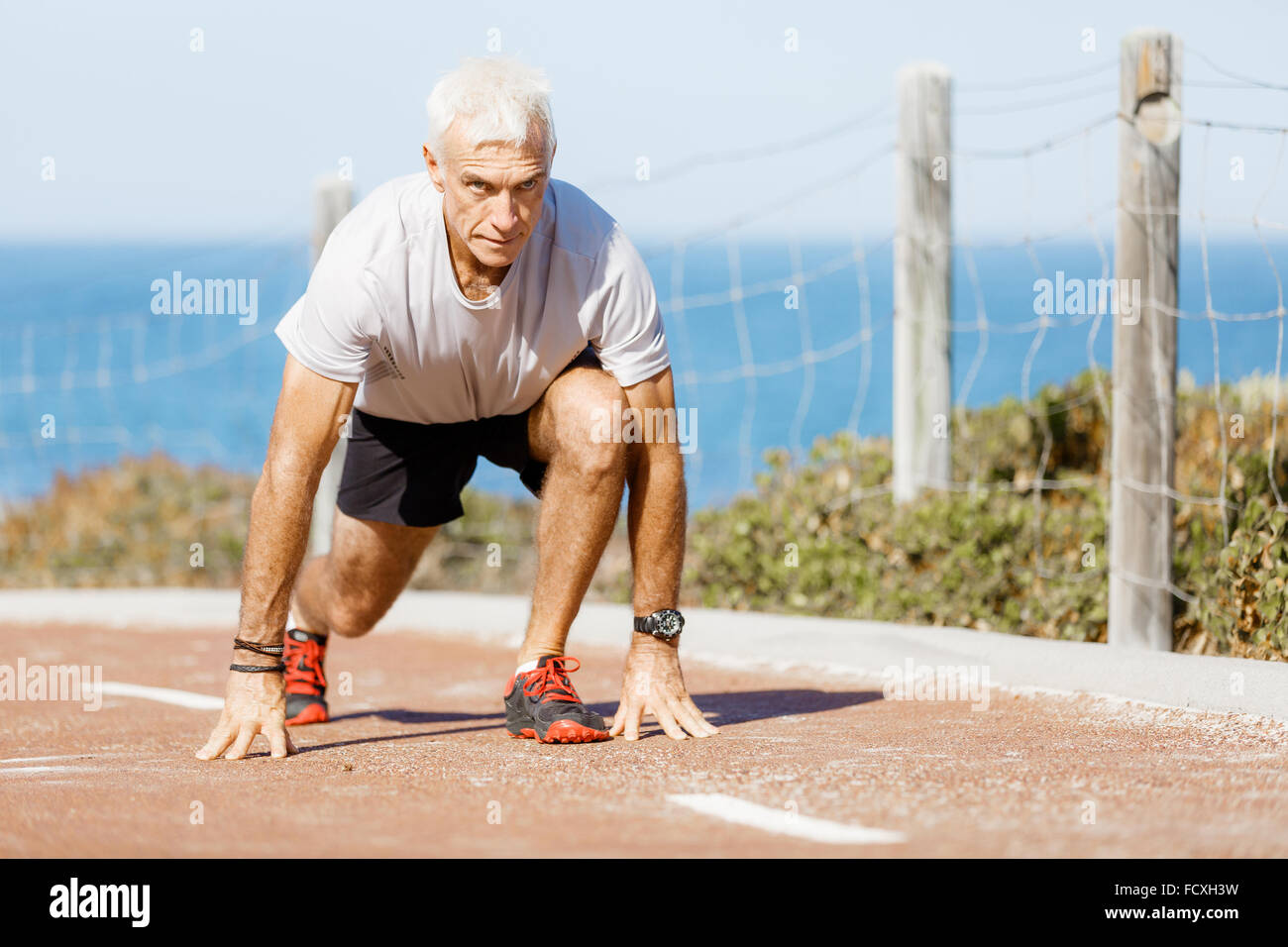 Male runner getting ready to start his race Stock Photo - Alamy