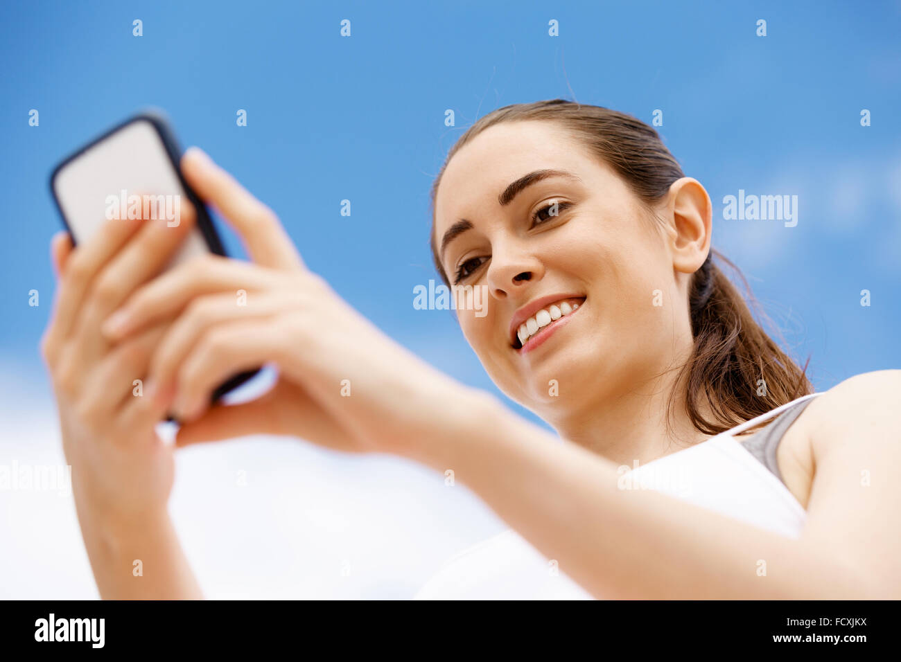 Young female runner with her mobile smart phone standing outdoors Stock ...