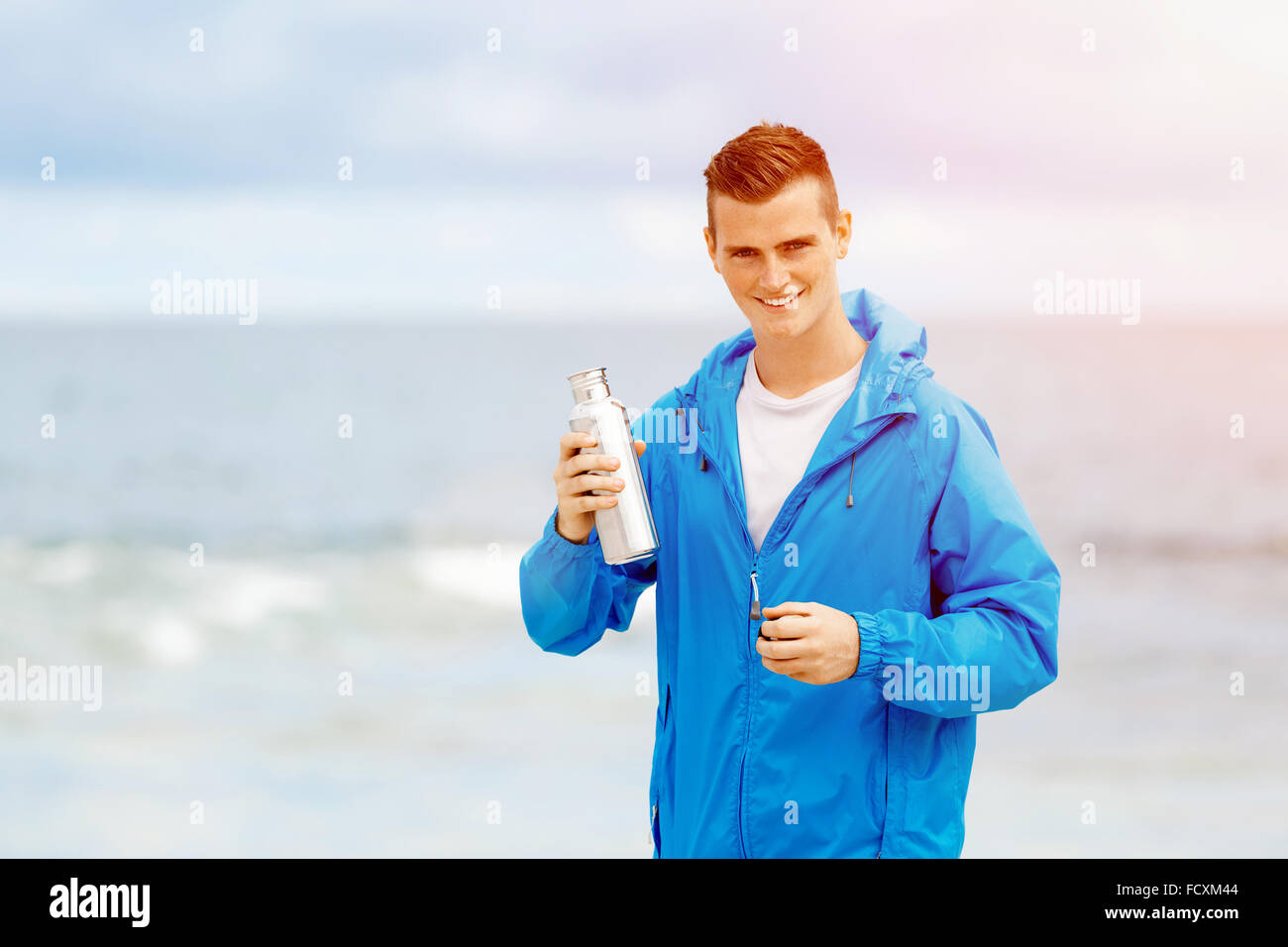 Young man in sport wear drinking from sports bottle Stock Photo - Alamy