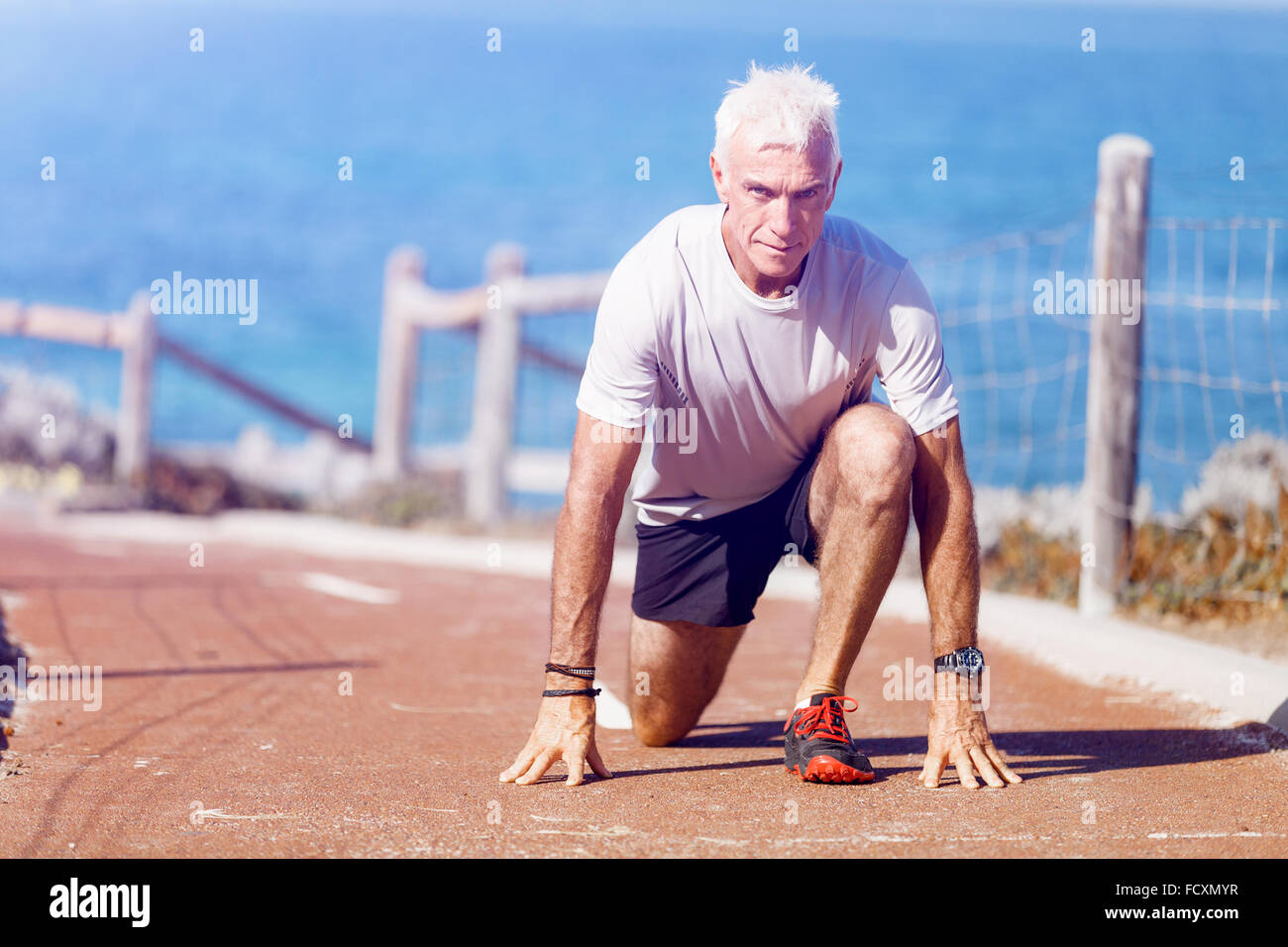 Male runner getting ready to start his race Stock Photo - Alamy