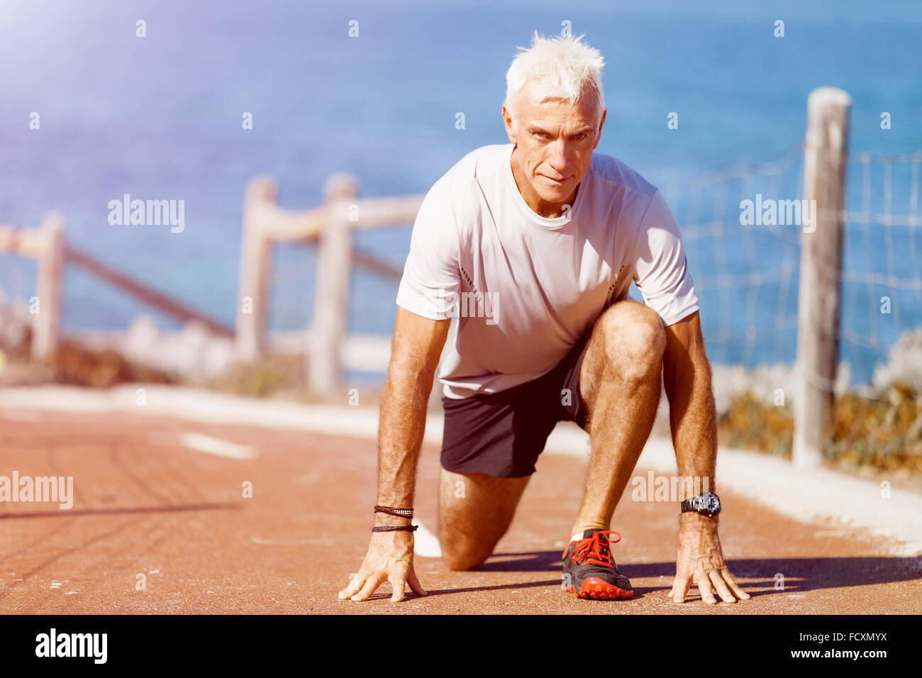 Male runner getting ready to start his race Stock Photo - Alamy