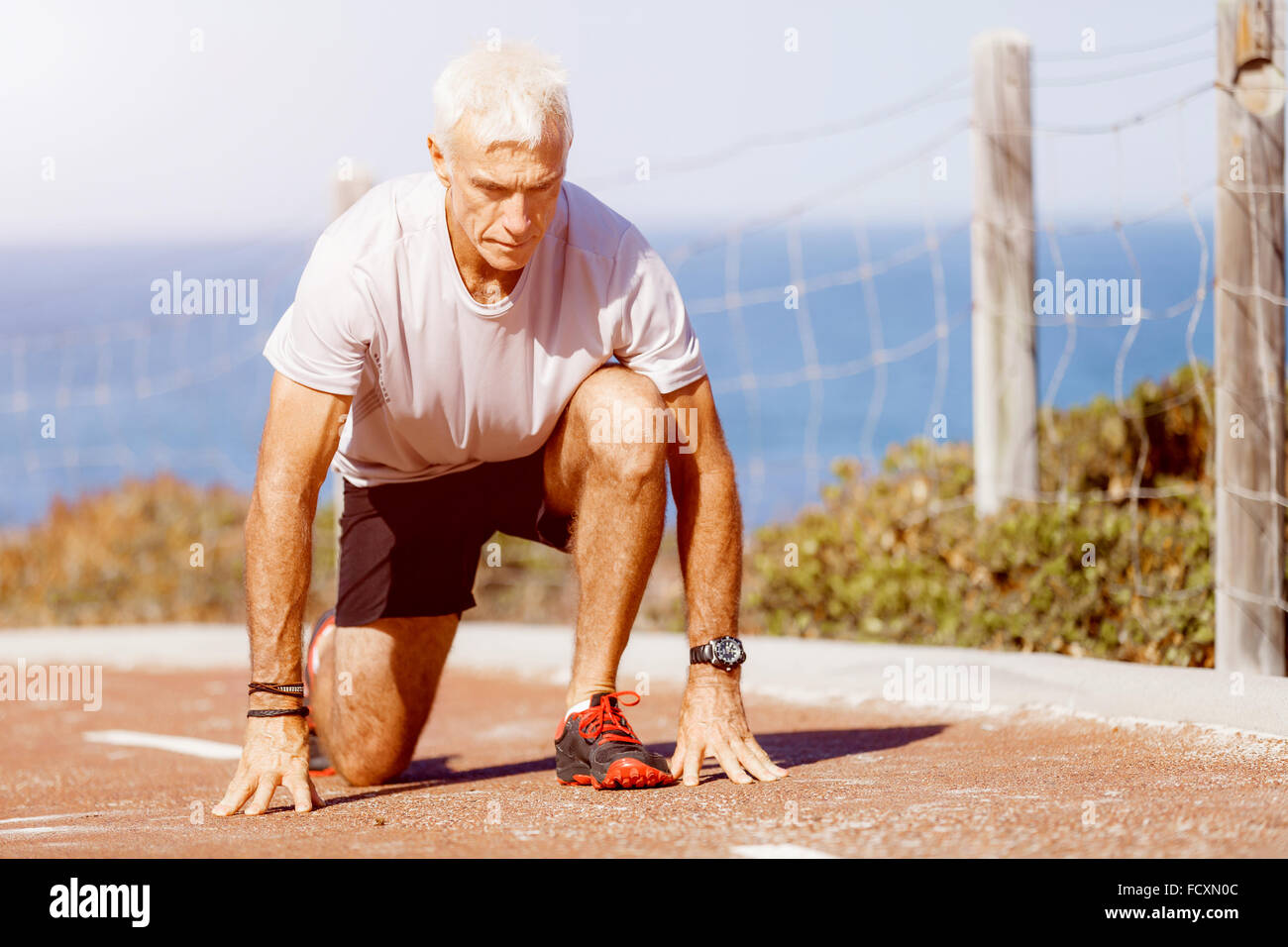 Male runner getting ready to start his race Stock Photo - Alamy