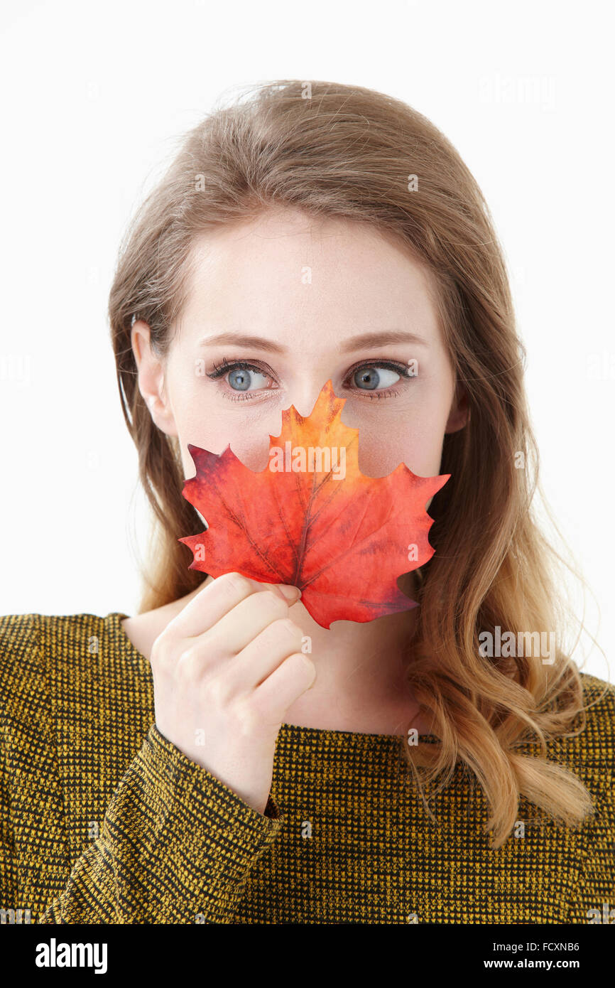 Portrait of young woman smelling a fallen leaf Stock Photo - Alamy