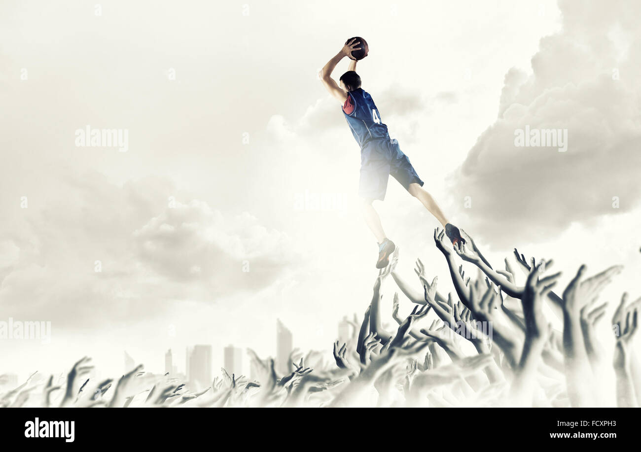 Young man basketball player with ball in hads jumping high Stock Photo ...