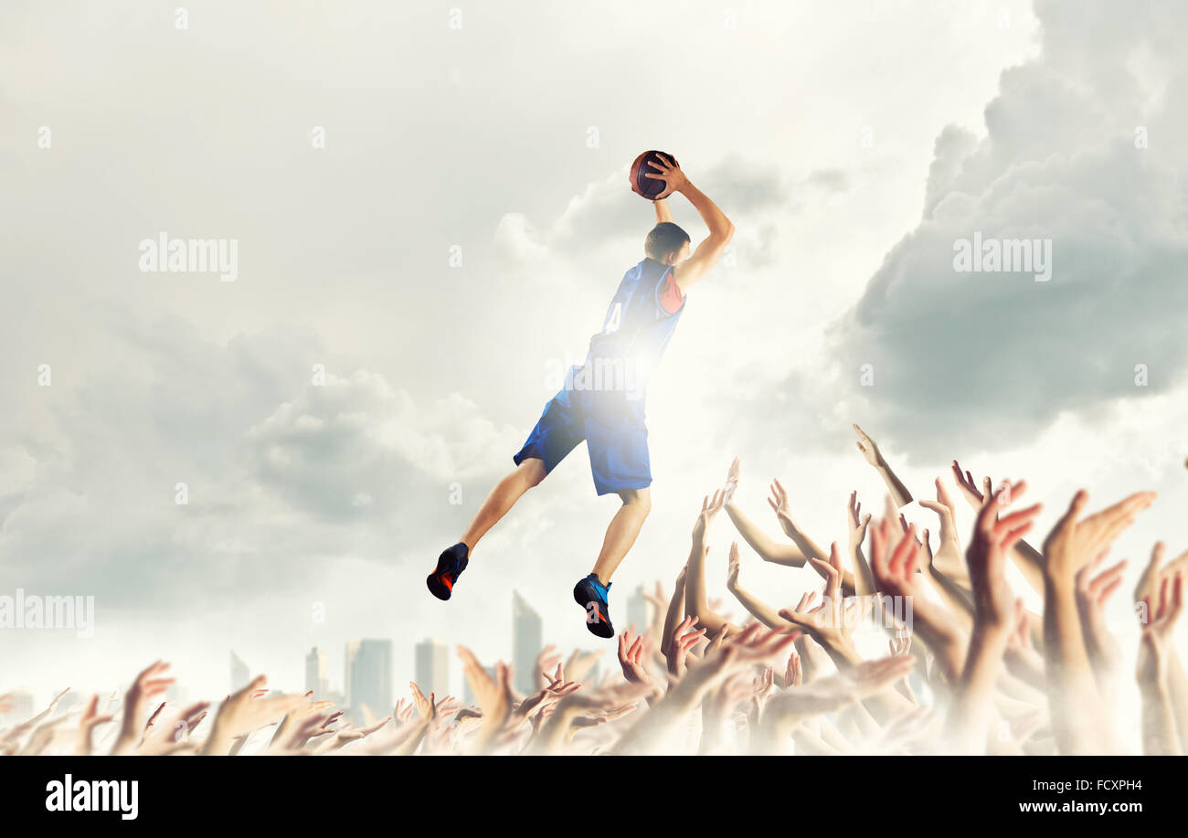 Young man basketball player with ball in hads jumping high Stock Photo ...