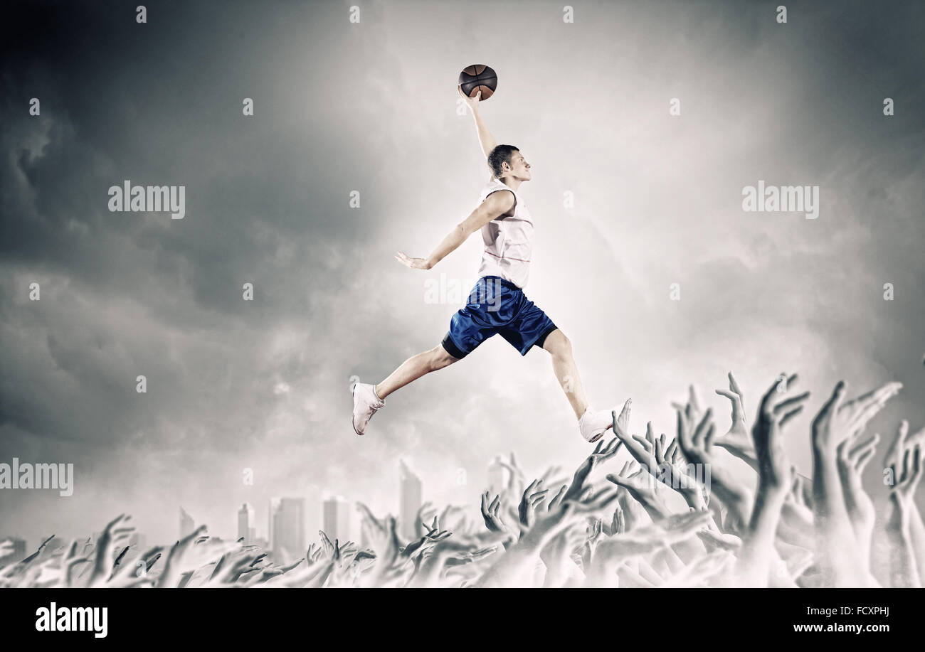 Young man basketball player with ball in hands jumping high Stock Photo ...