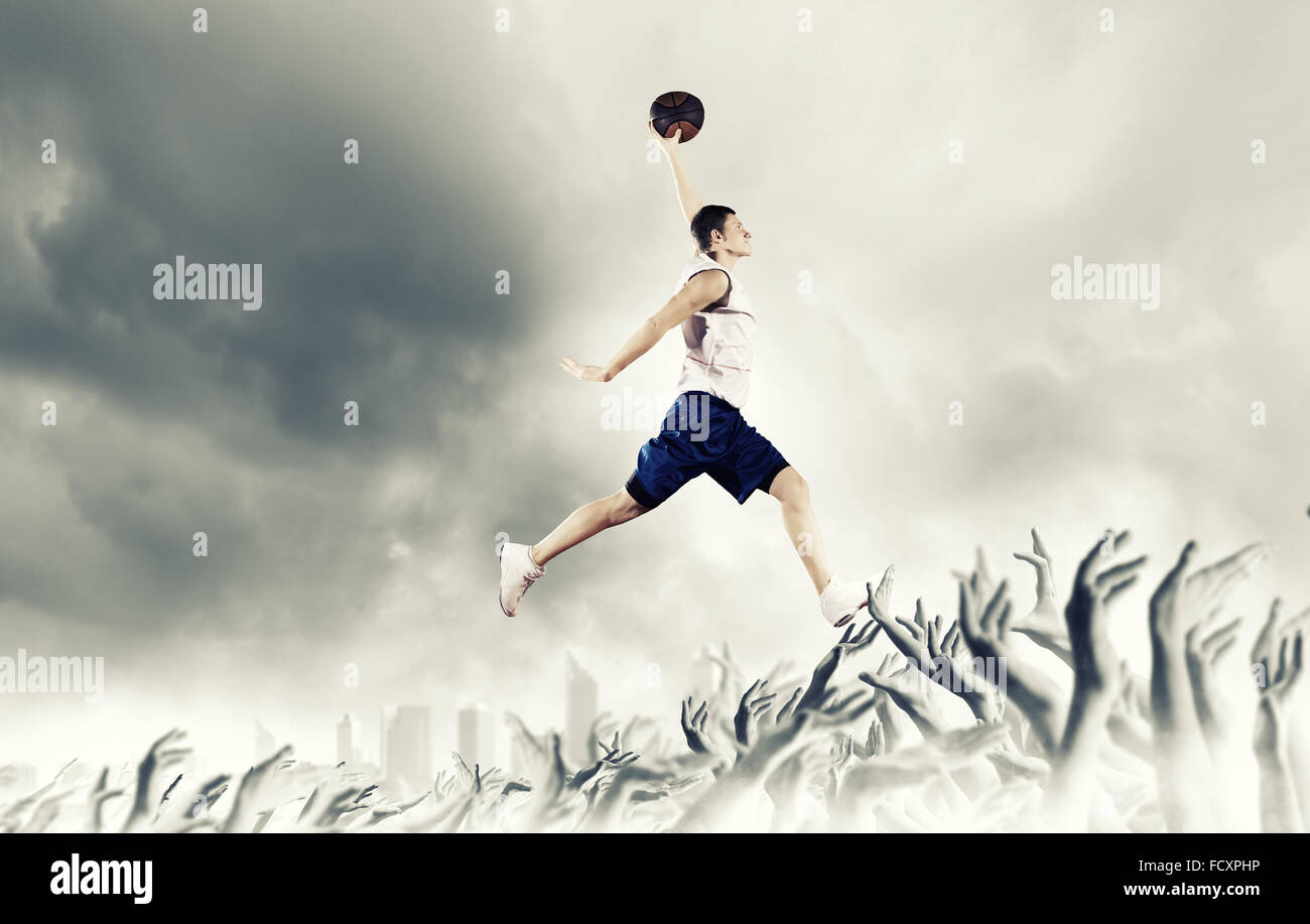 Young man basketball player with ball in hands jumping high Stock Photo ...