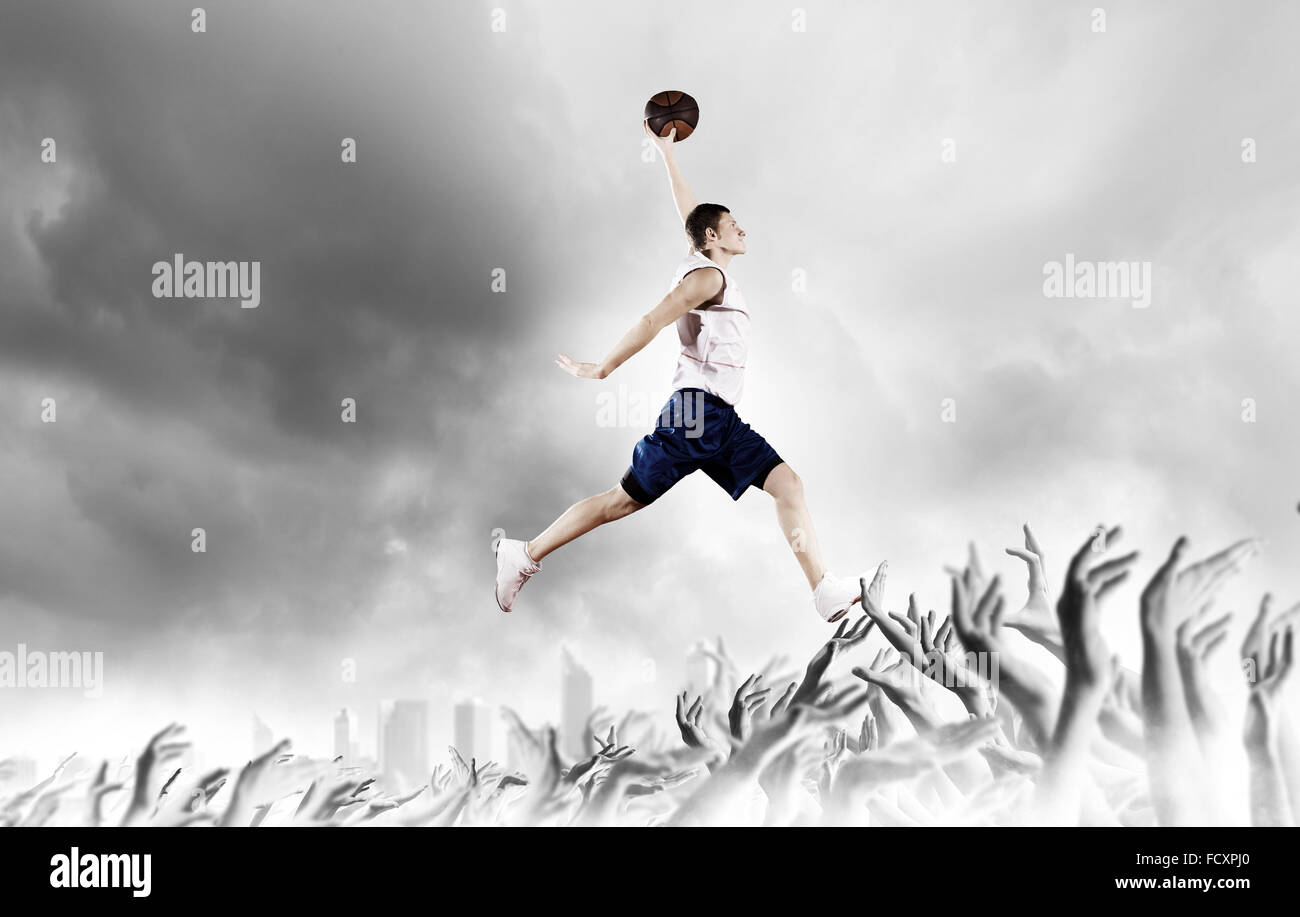 Young man basketball player with ball in hands jumping high Stock Photo ...