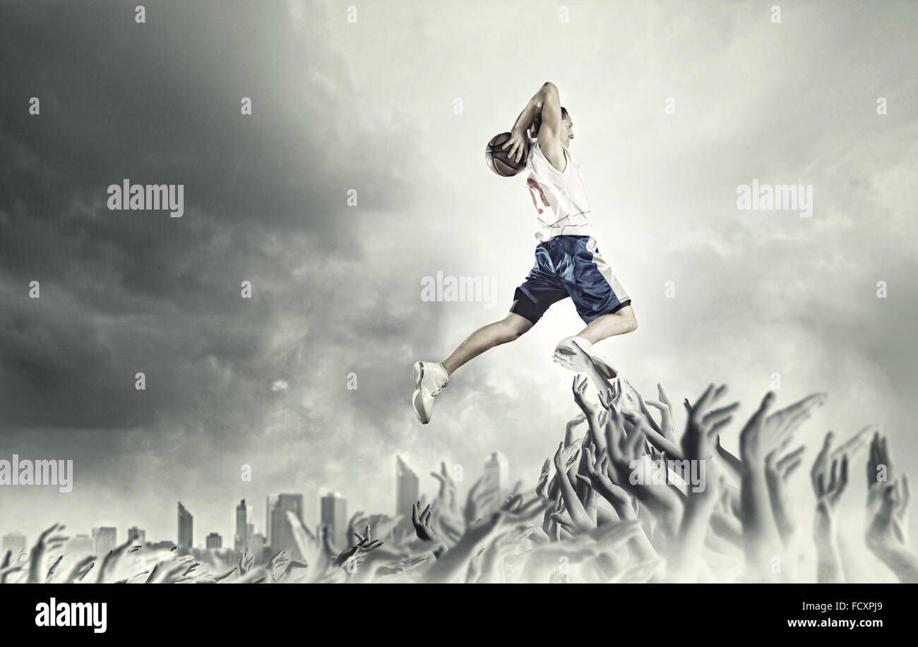 Young man basketball player with ball in hands jumping high Stock Photo ...