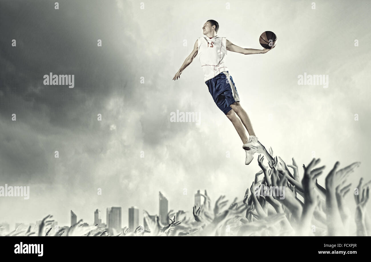 Young man basketball player with ball in hands jumping high Stock Photo ...