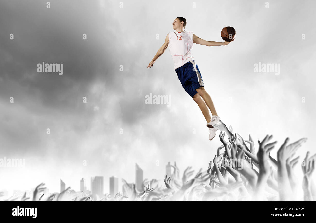 Young man basketball player with ball in hands jumping high Stock Photo ...