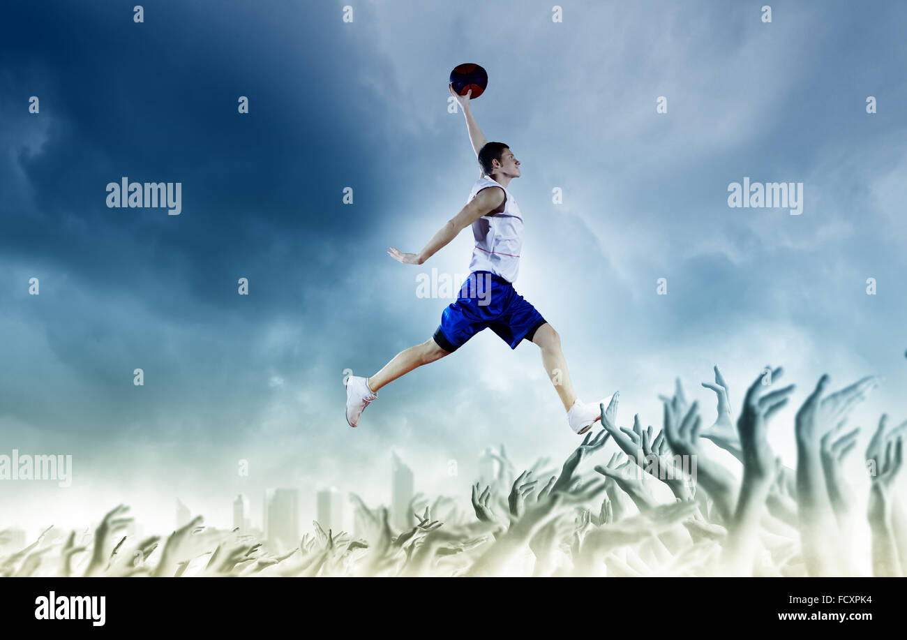 Young man basketball player with ball in hands jumping high Stock Photo ...