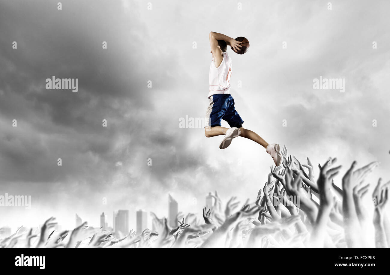 Young man basketball player with ball in hands jumping high Stock Photo ...