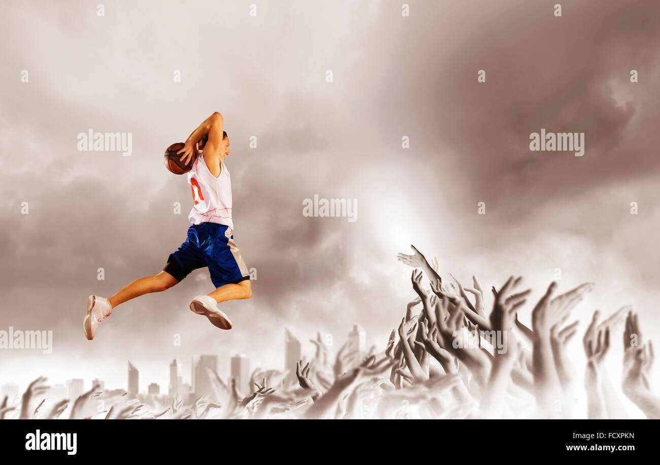 Young man basketball player with ball in hands jumping high Stock Photo ...