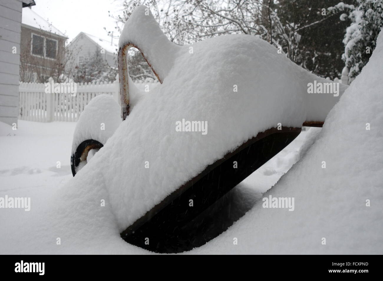 Snow covered wheelbarrow Stock Photo - Alamy