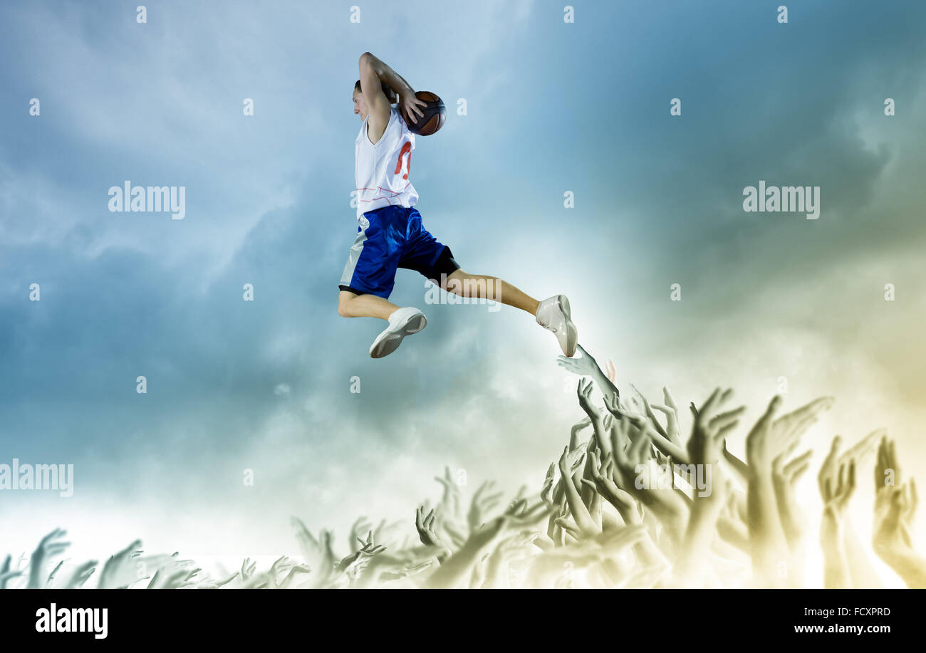 Young man basketball player with ball in hands jumping high Stock Photo ...