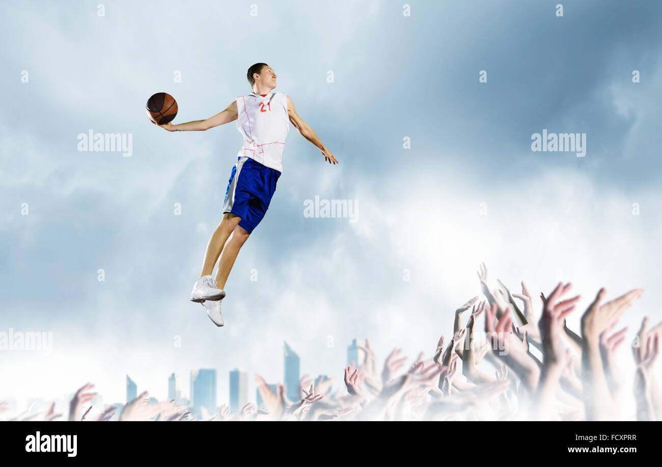 Young man basketball player with ball in hands jumping high Stock Photo ...