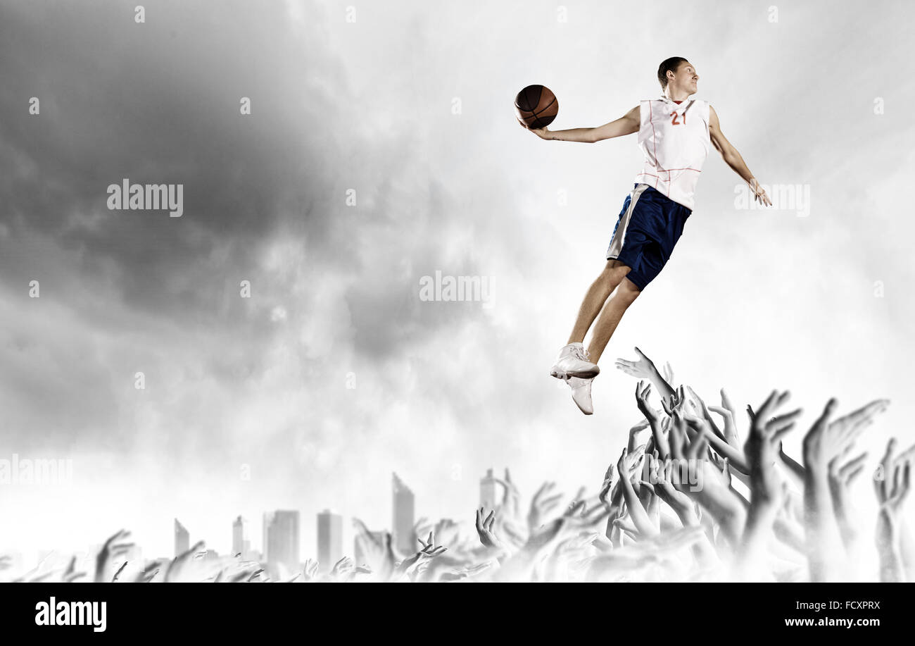 Young man basketball player with ball in hands jumping high Stock Photo ...