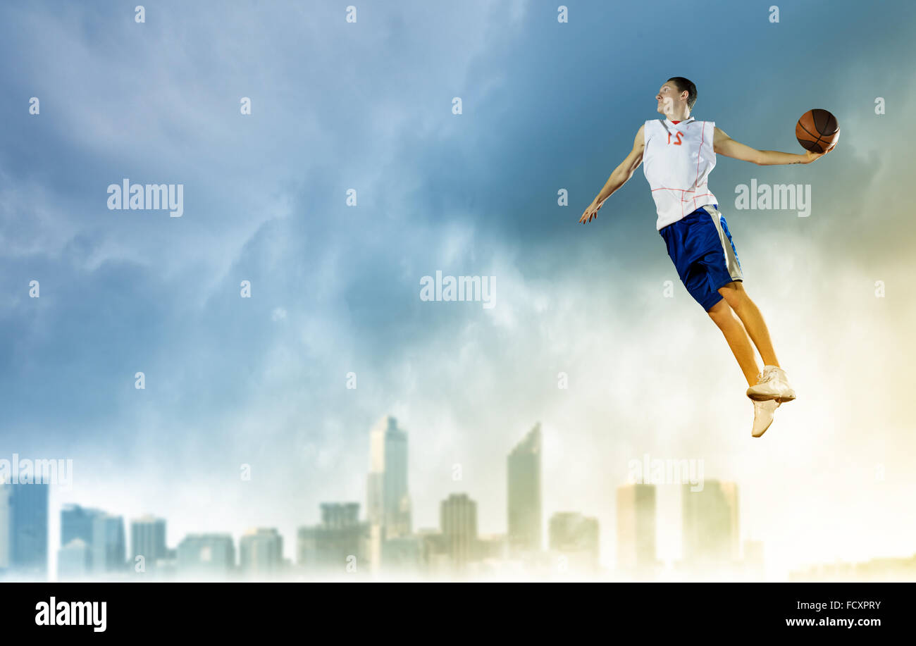 Young man basketball player with ball in hands jumping high Stock Photo ...