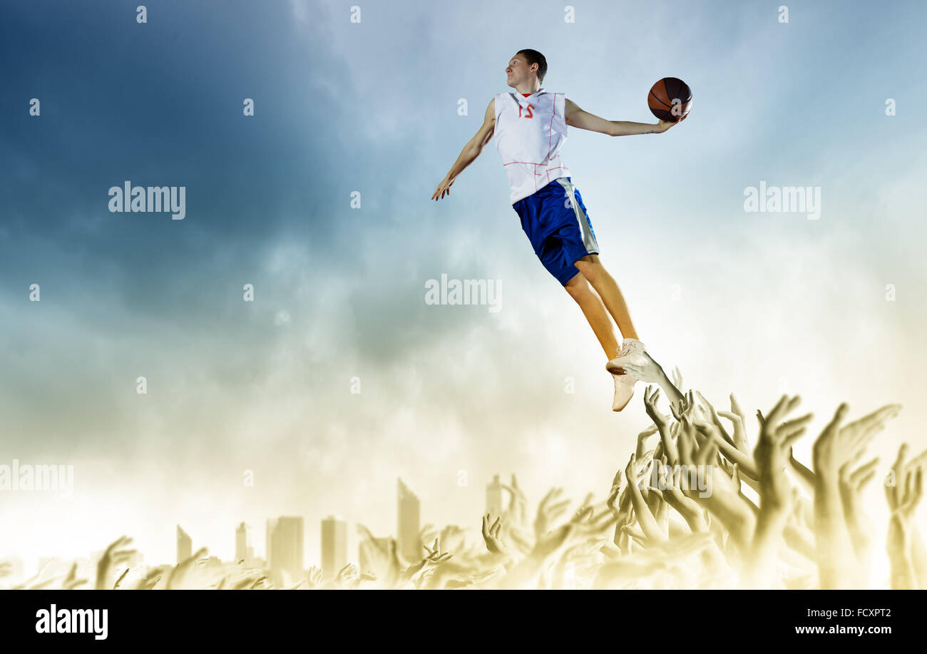 Young man basketball player with ball in hands jumping high Stock Photo ...