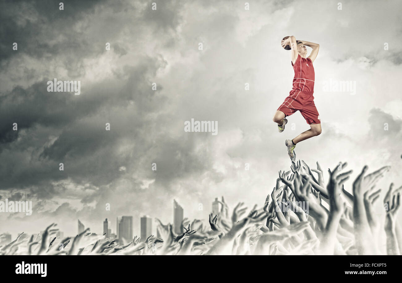 Young man basketball player with ball in hands jumping high Stock Photo ...