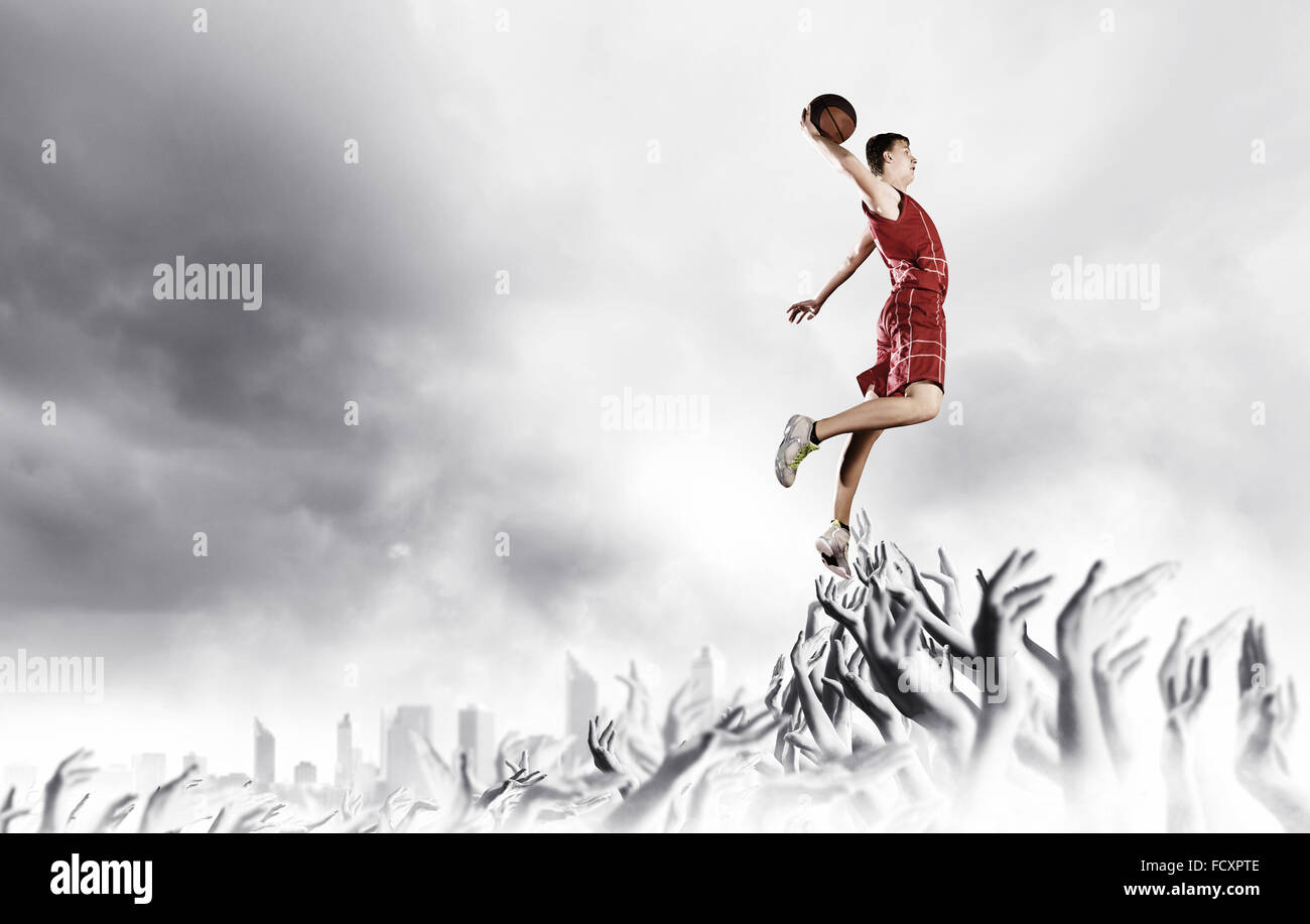 Young man basketball player with ball in hands jumping high Stock Photo ...