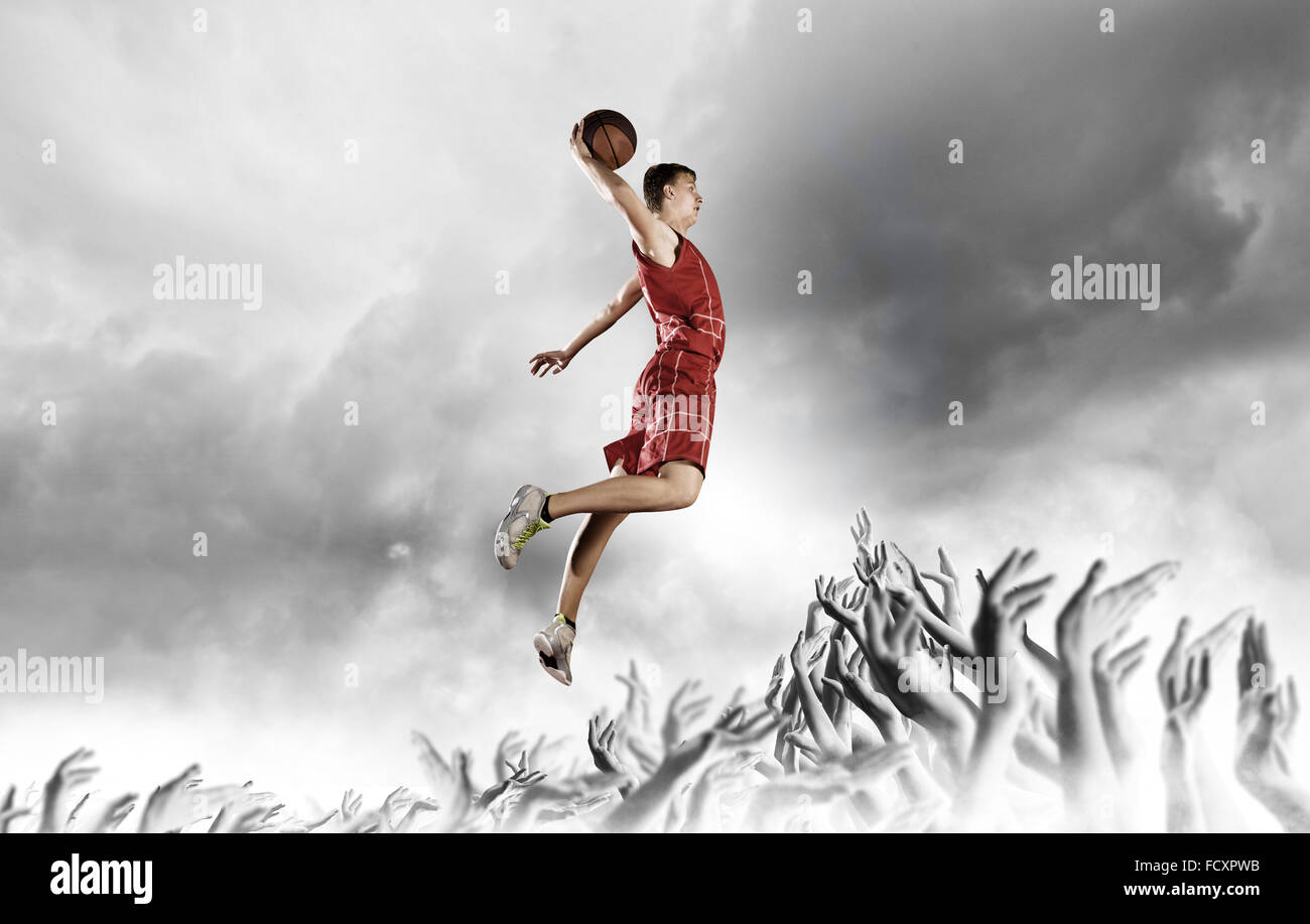 Young man basketball player with ball in hands jumping high Stock Photo ...