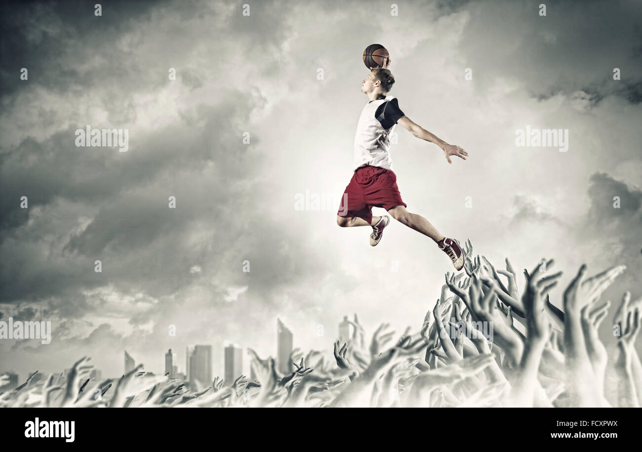 Young man basketball player with ball in hands jumping high Stock Photo ...