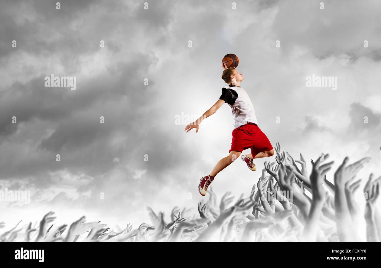Young man basketball player with ball in hands jumping high Stock Photo ...