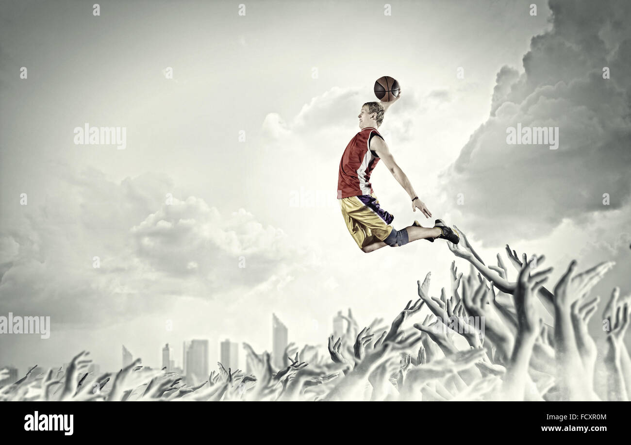 Young man basketball player with ball in hands jumping high Stock Photo ...