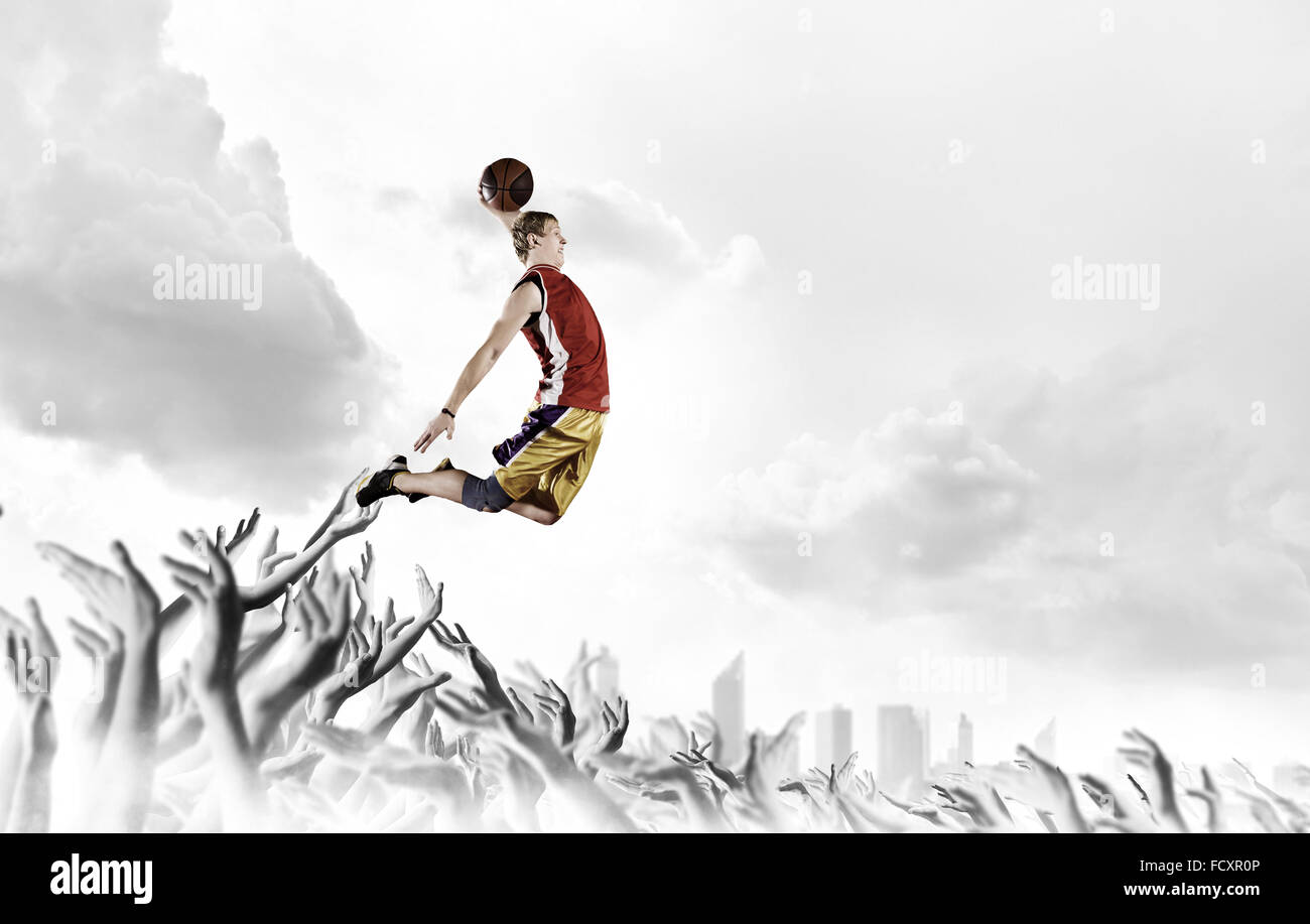 Young man basketball player with ball in hands jumping high Stock Photo ...