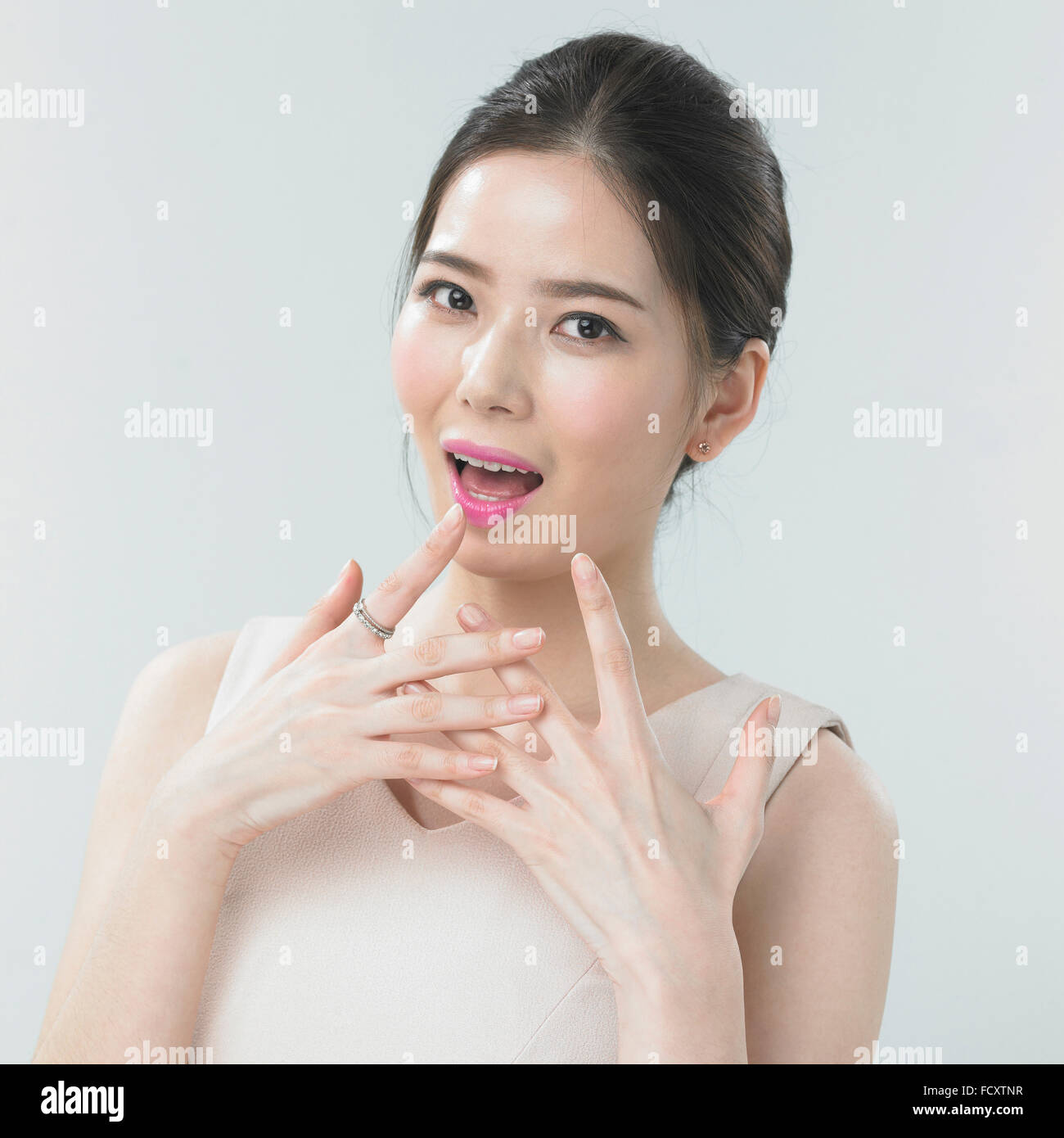 Portrait of young smiling woman with pink lips raising hands Stock ...