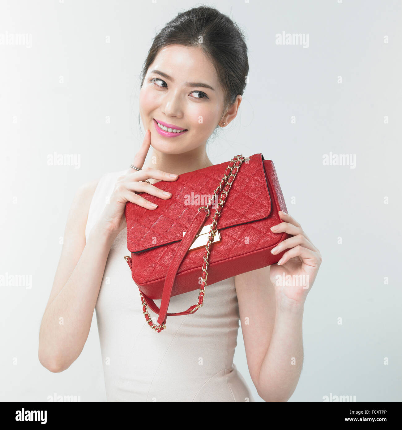 Portrait of young smilng woman posing with a red bag Stock Photo - Alamy