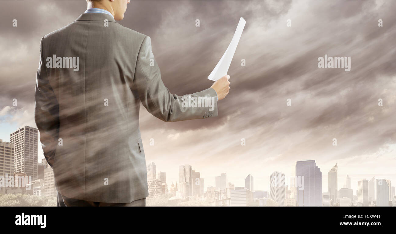 Back view of businessman reading documents in hand Stock Photo - Alamy