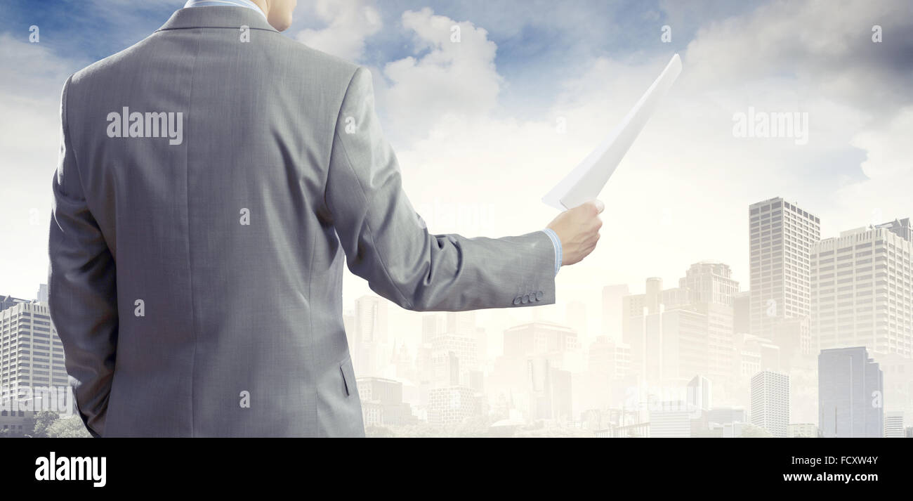 Back view of businessman reading documents in hand Stock Photo - Alamy