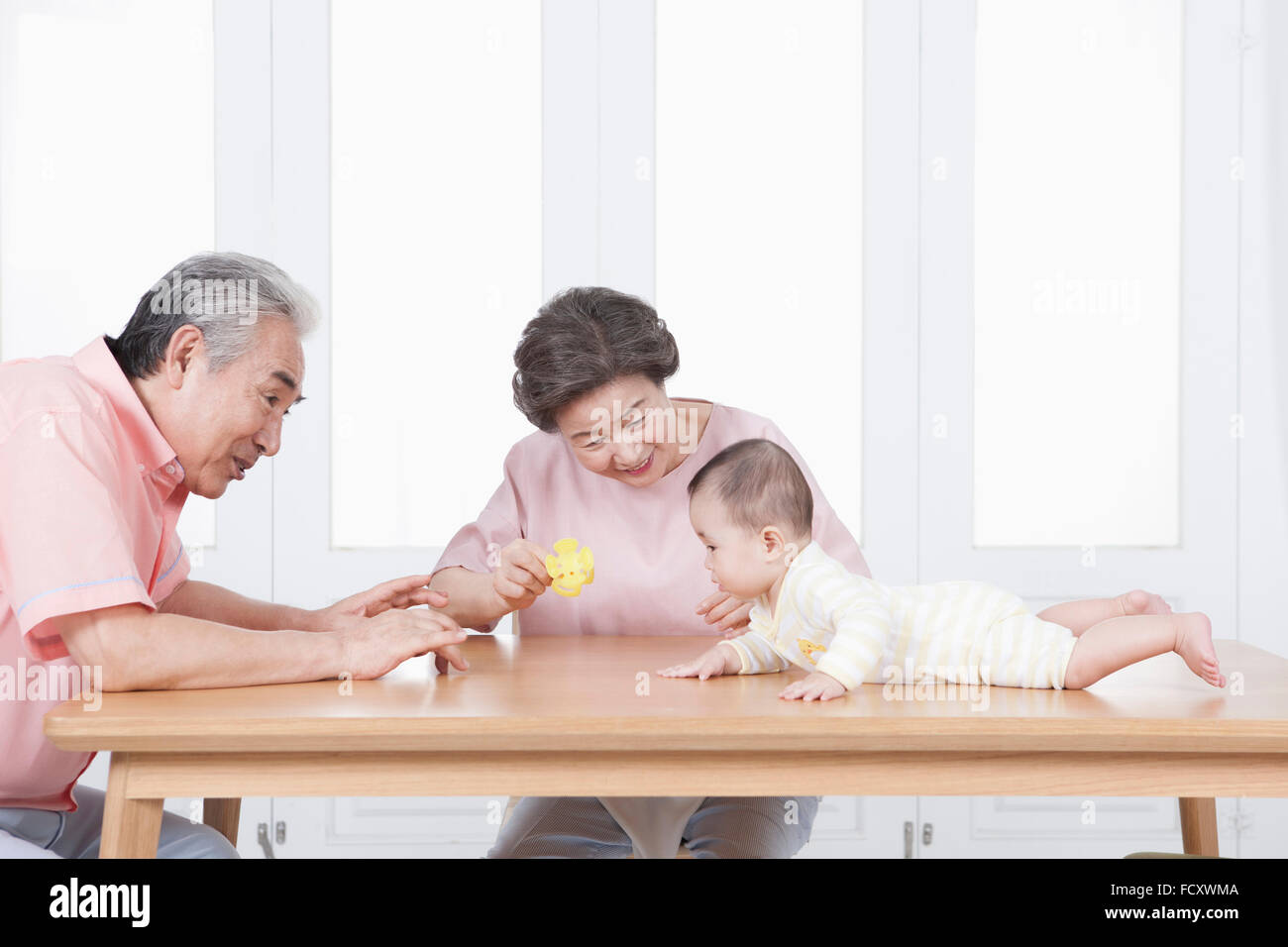 Old couple playing with a baby Stock Photo - Alamy