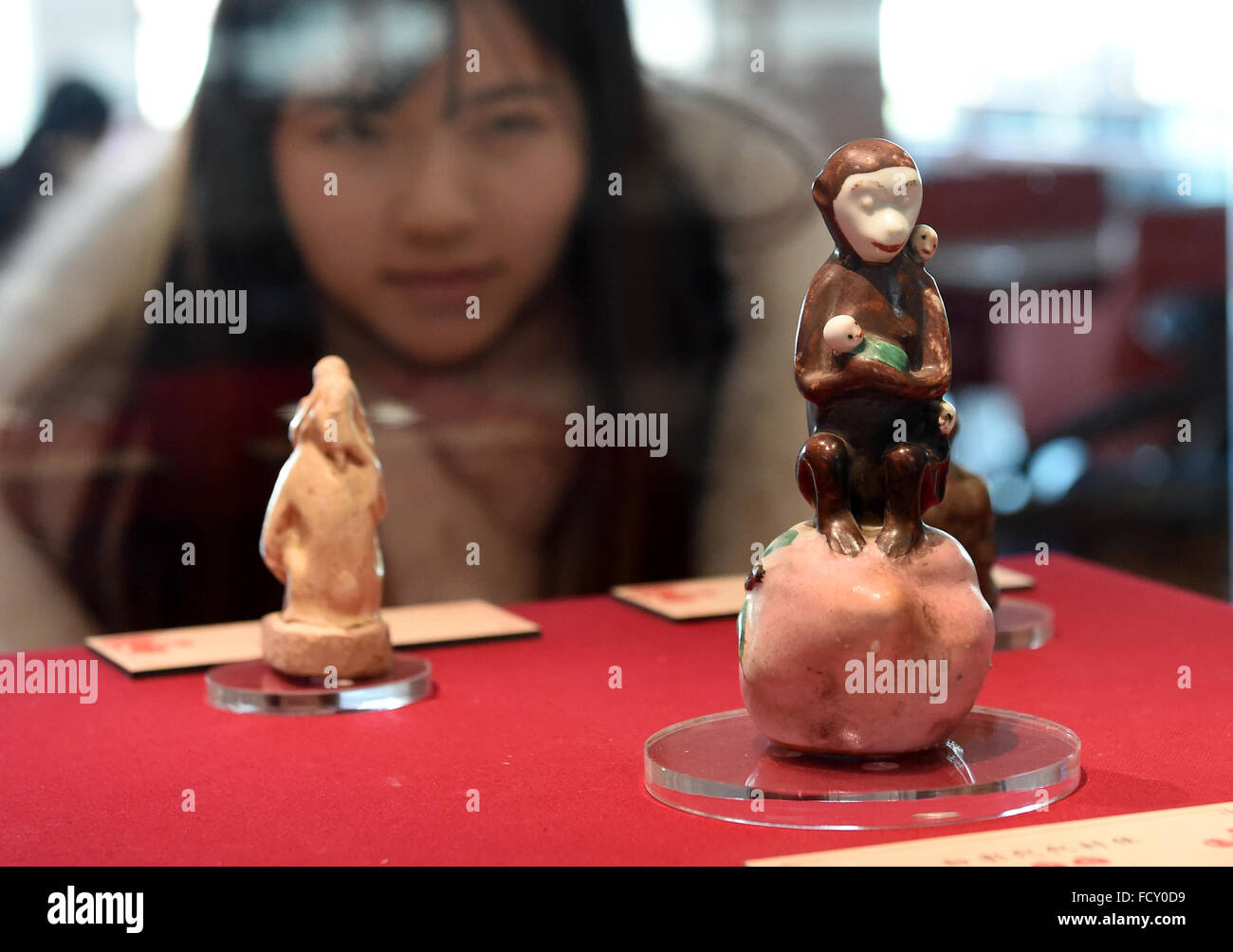 Nanjing. 25th Jan, 2016. A visitor looks at porcelains of monkey at ...