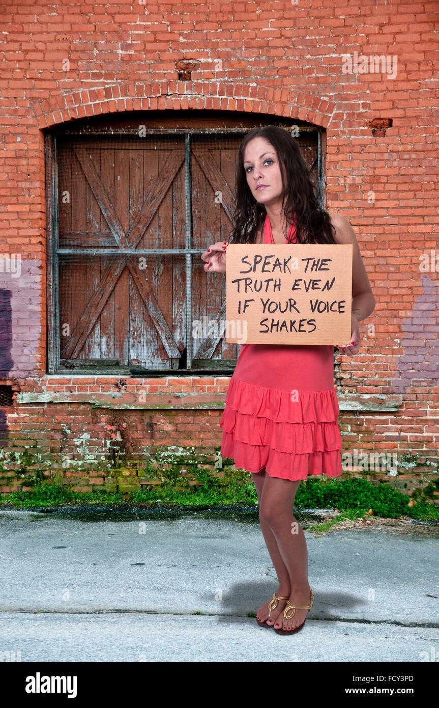A beautiful young woman holding up a sign Stock Photo - Alamy