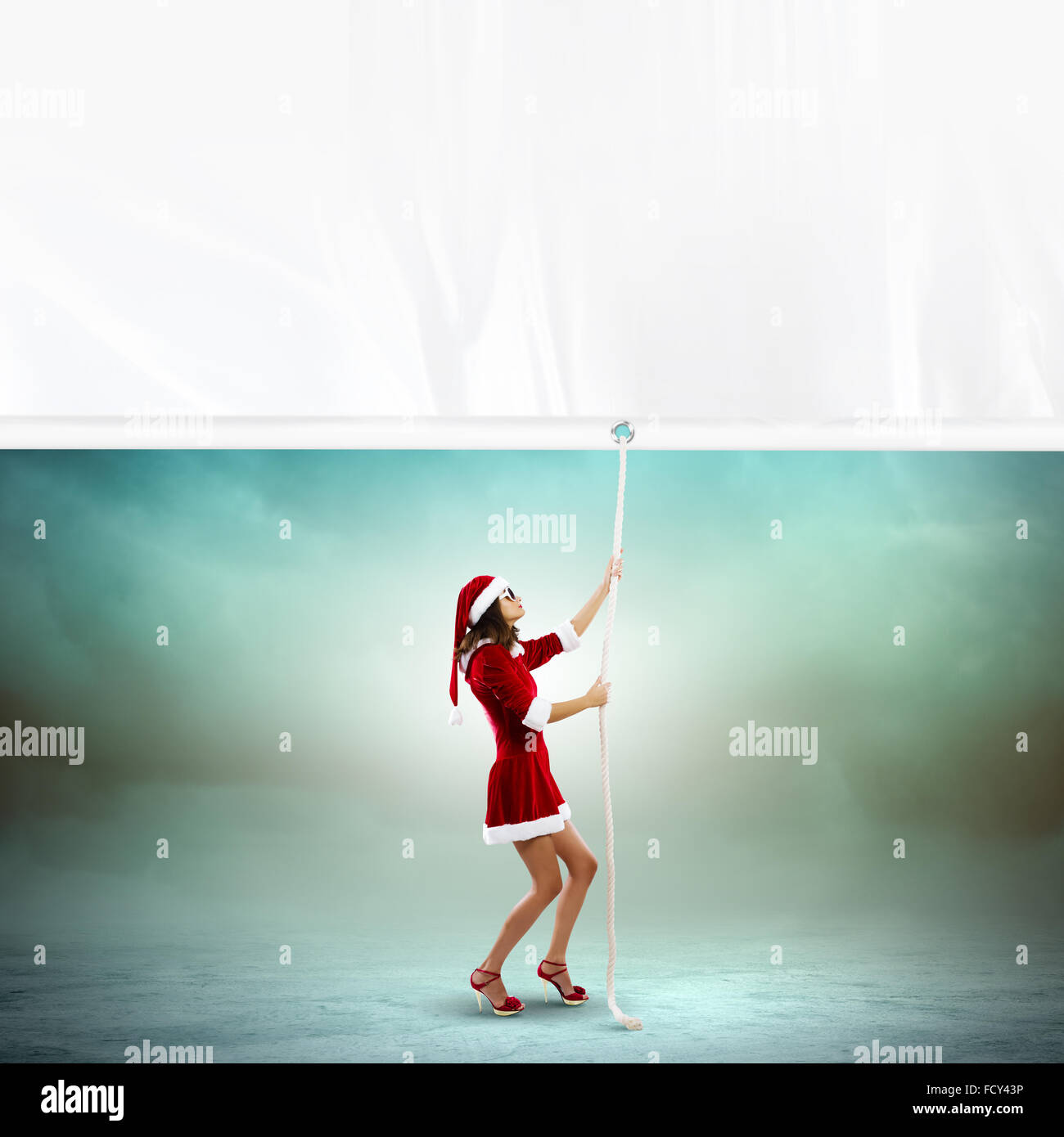 Girl in Santa costume pulling white blank banner. Place for text Stock ...