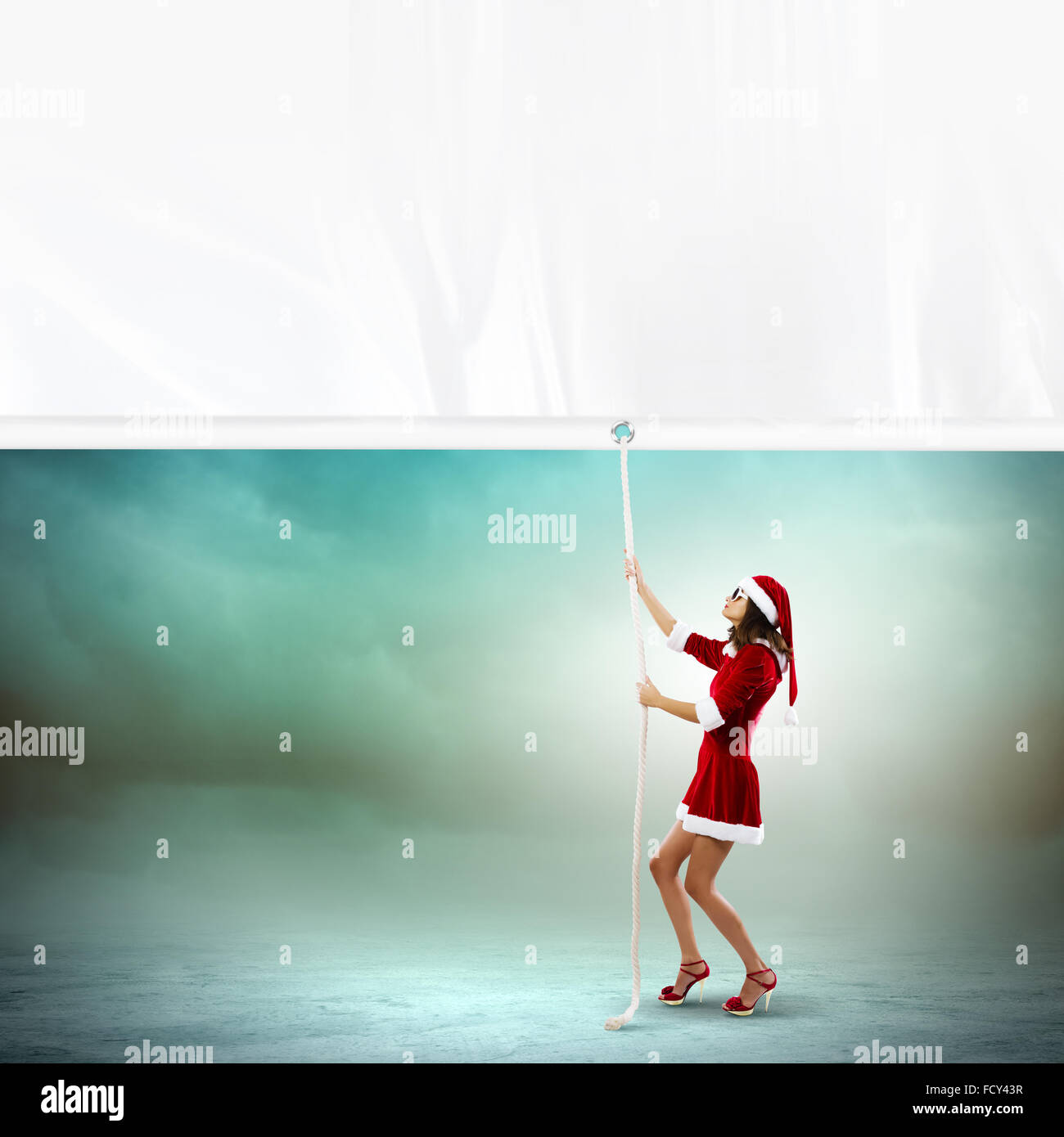 Girl in Santa costume pulling white blank banner. Place for text Stock ...